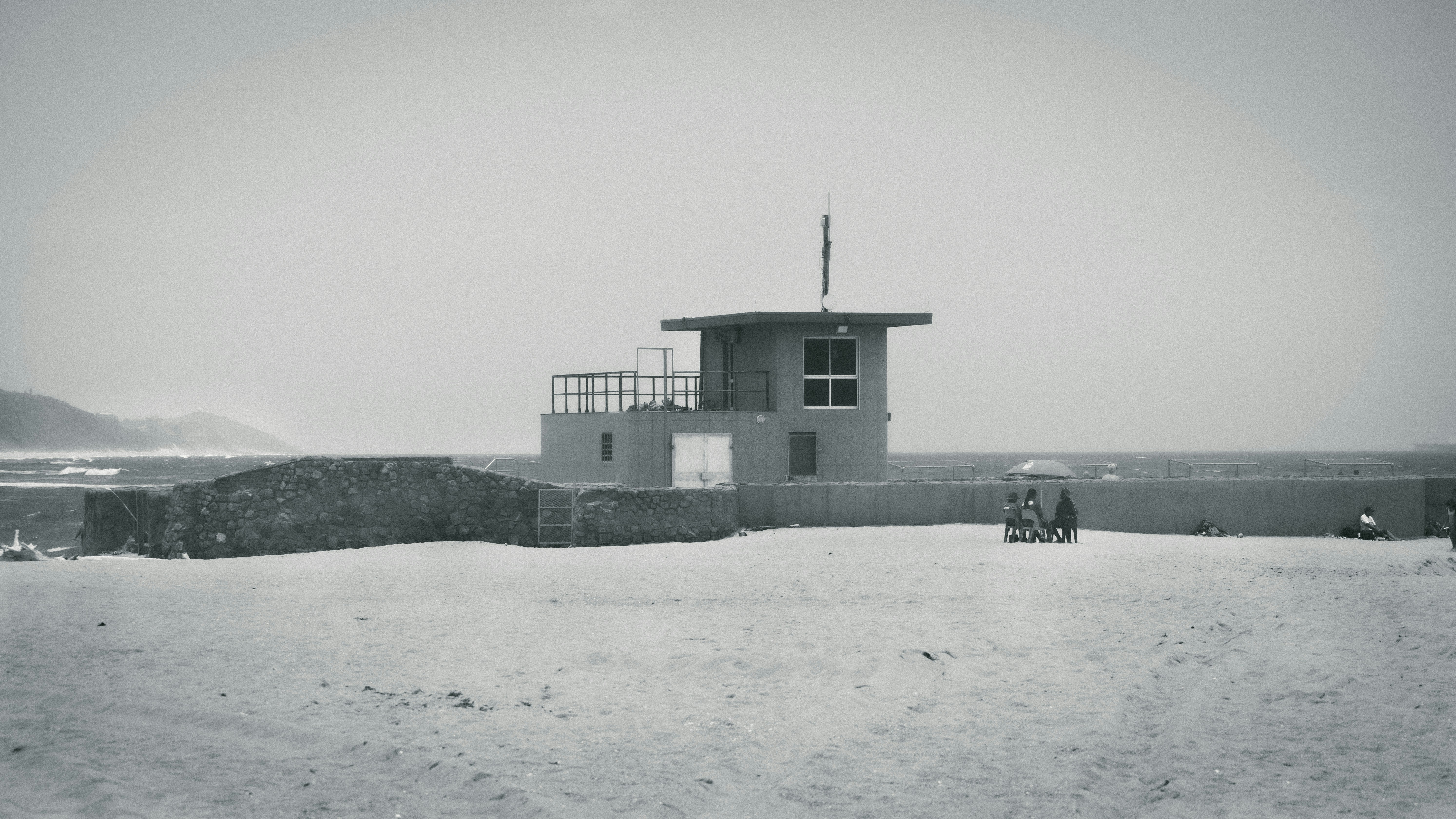 Breakwater Sentinel: A Quiet Lifeguard Tower in Monochrome