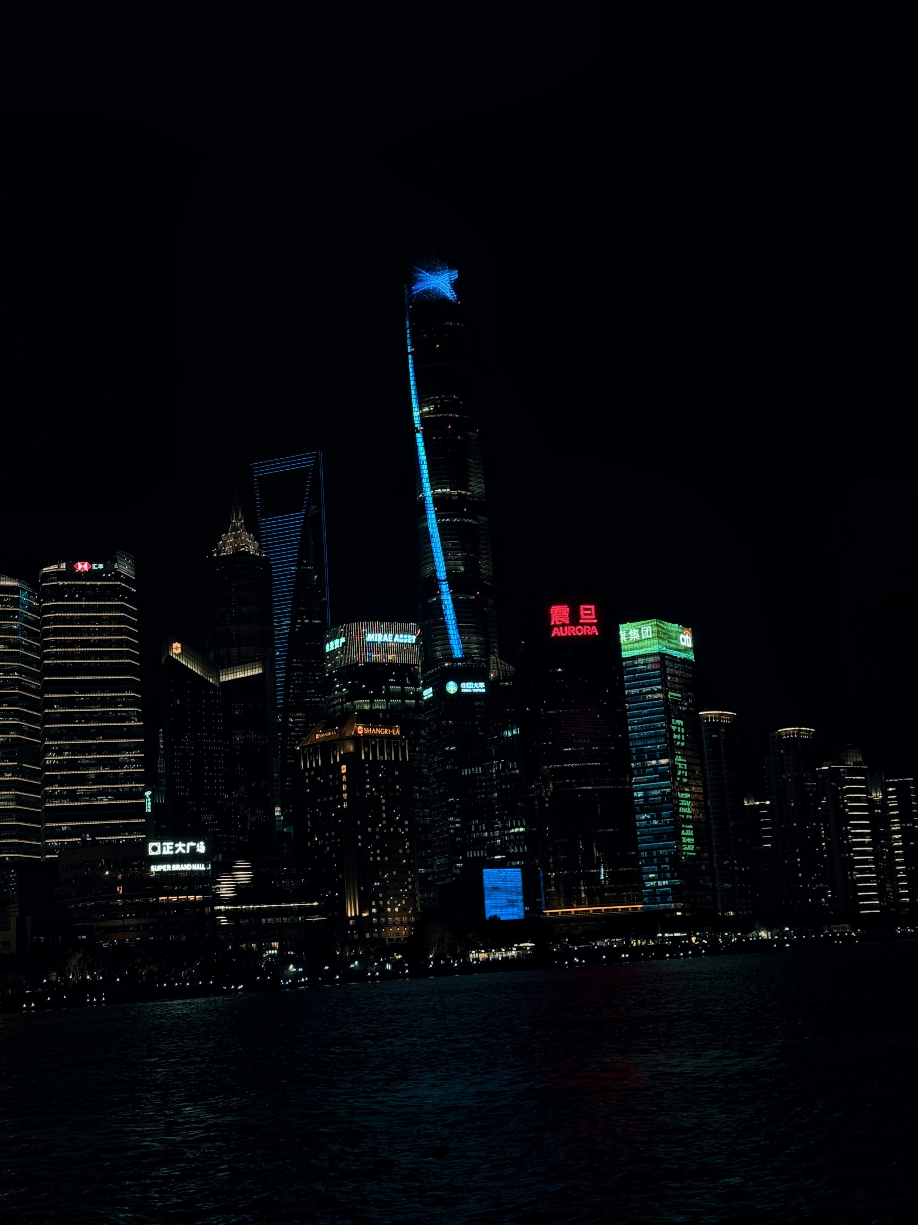 Blue Pillar at Dusk: A Neon Skyline by the Waterfront