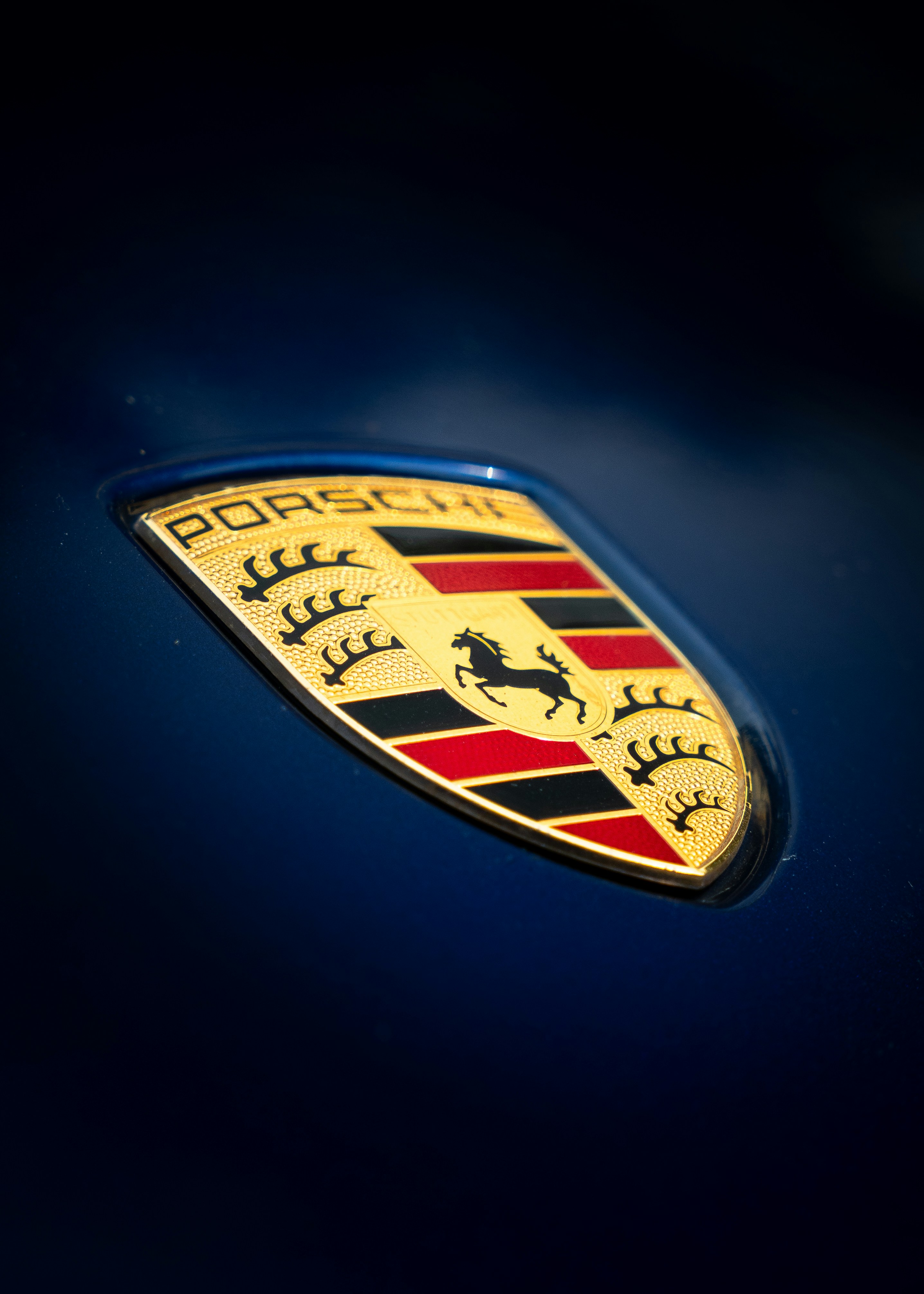 Gold Porsche Crest on Velvet Blue: A Close-Up Emblem Portrait