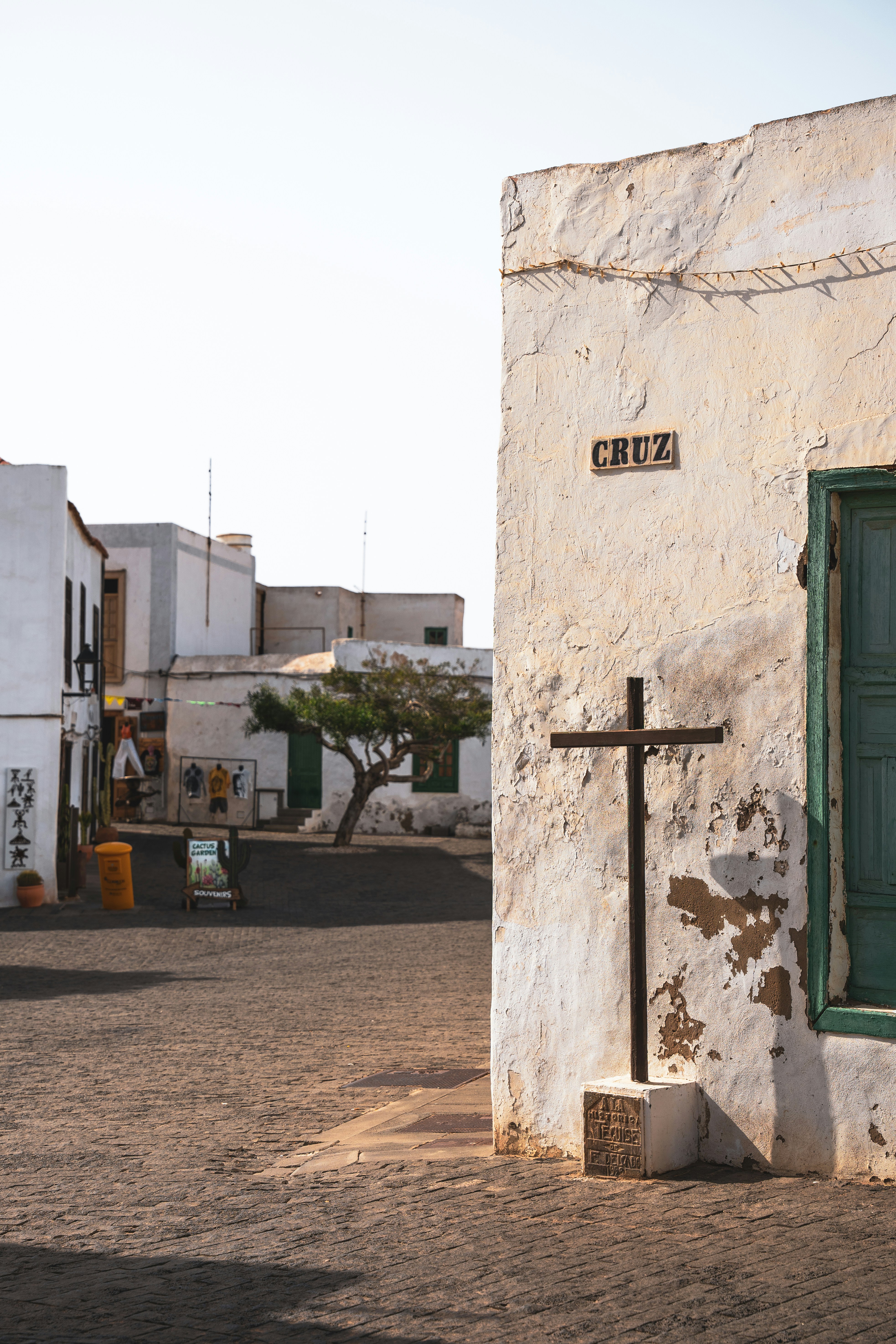 Cruz Corner: Sunlit Whitewashed Plaza with a Lone Cross