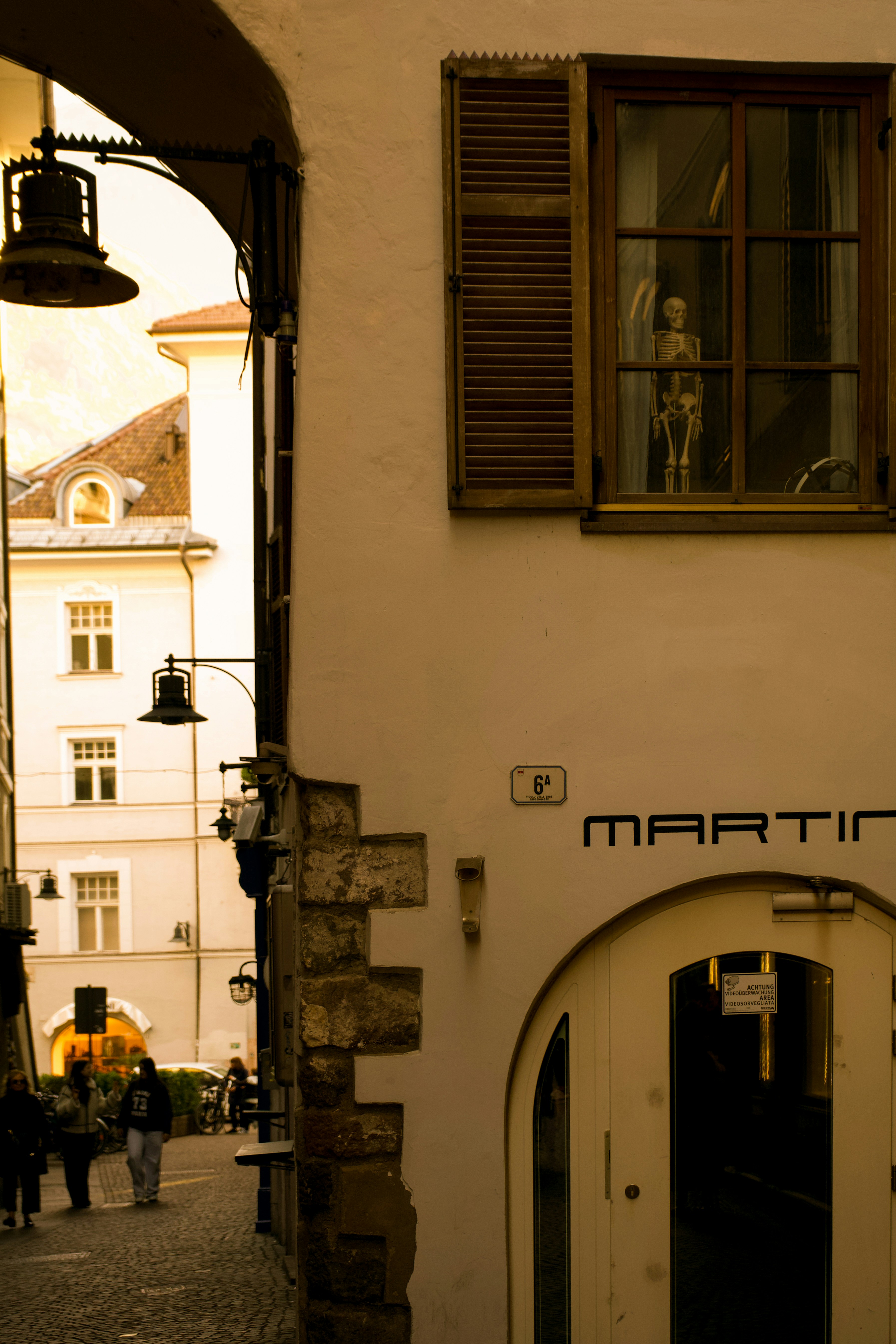 Skeleton in the Window: A Sunlit European Street Scene
