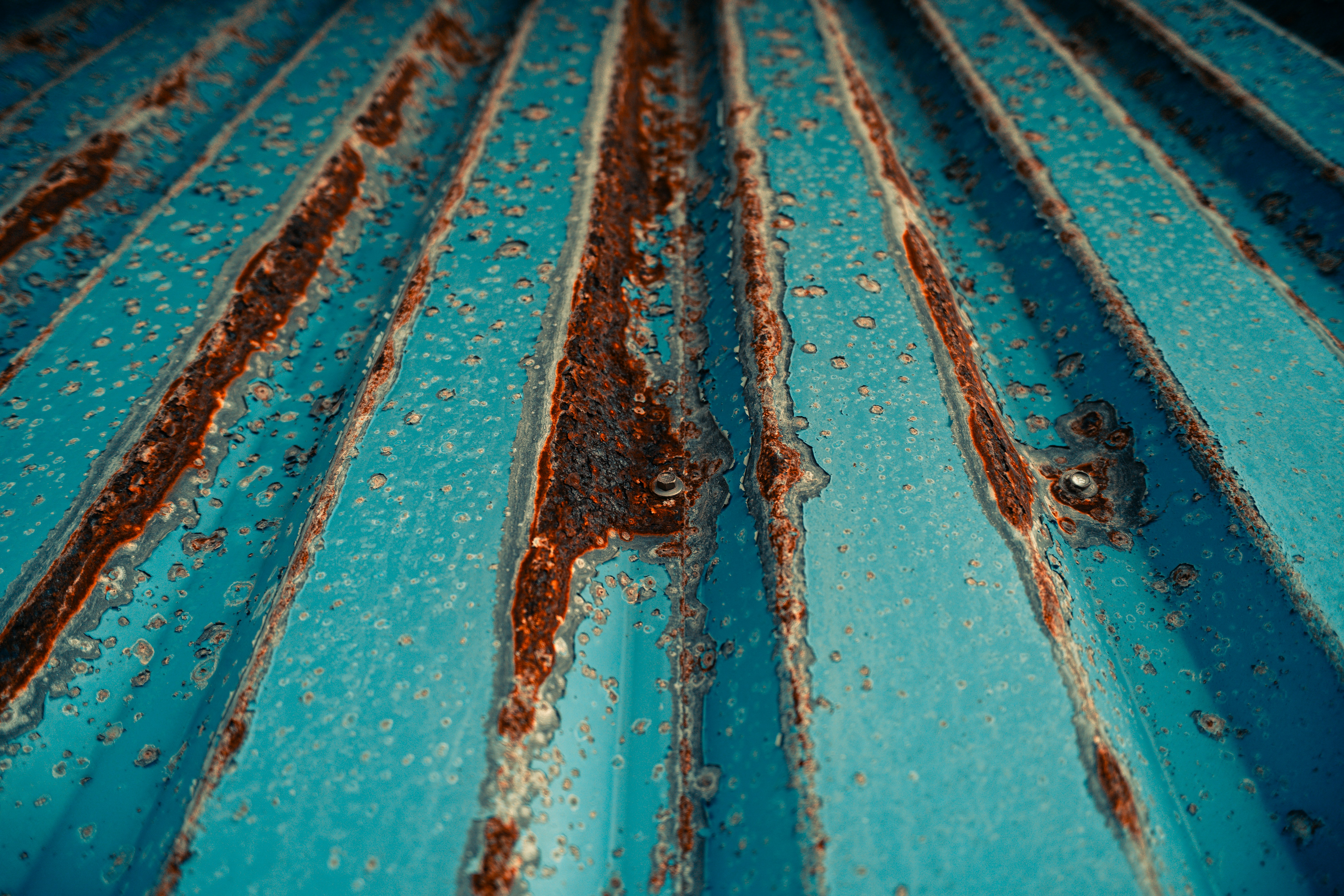 Rust Veins on Turquoise Corrugation: A Close-Up of Weathered Metal