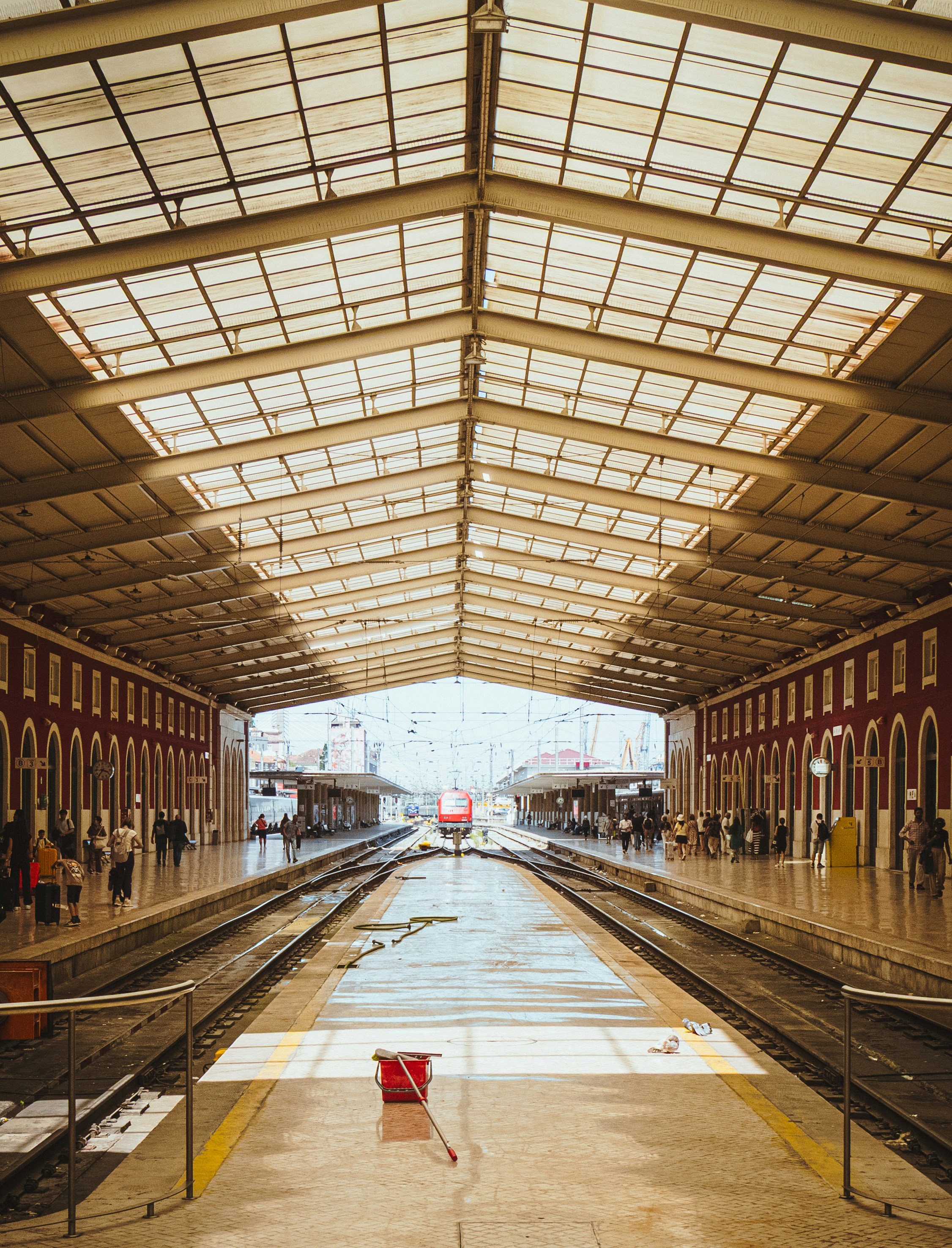 Convergence at Dawn: Rails, Glass Roof, and a Red Train