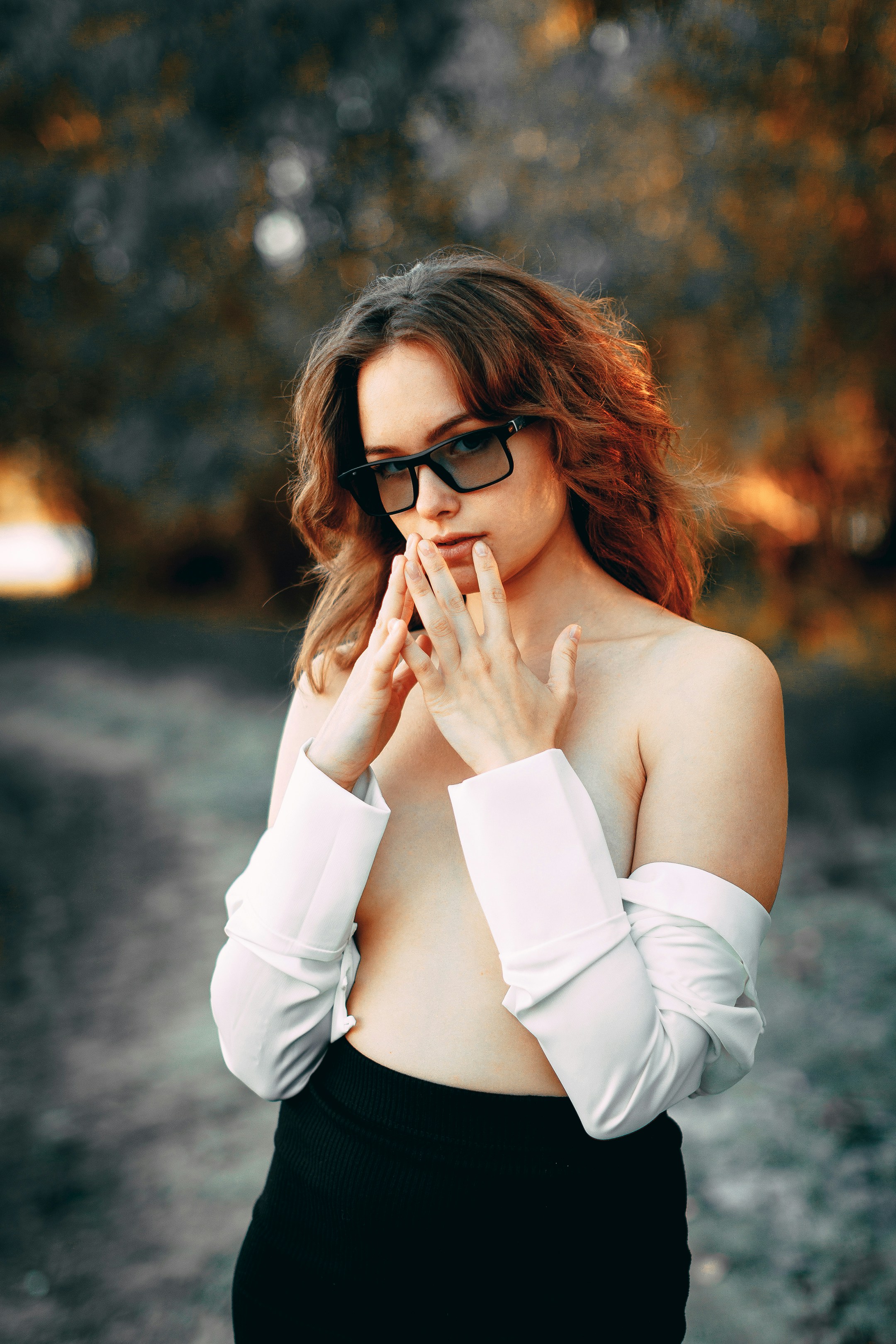 Young woman with curly hair wearing glasses outdoors