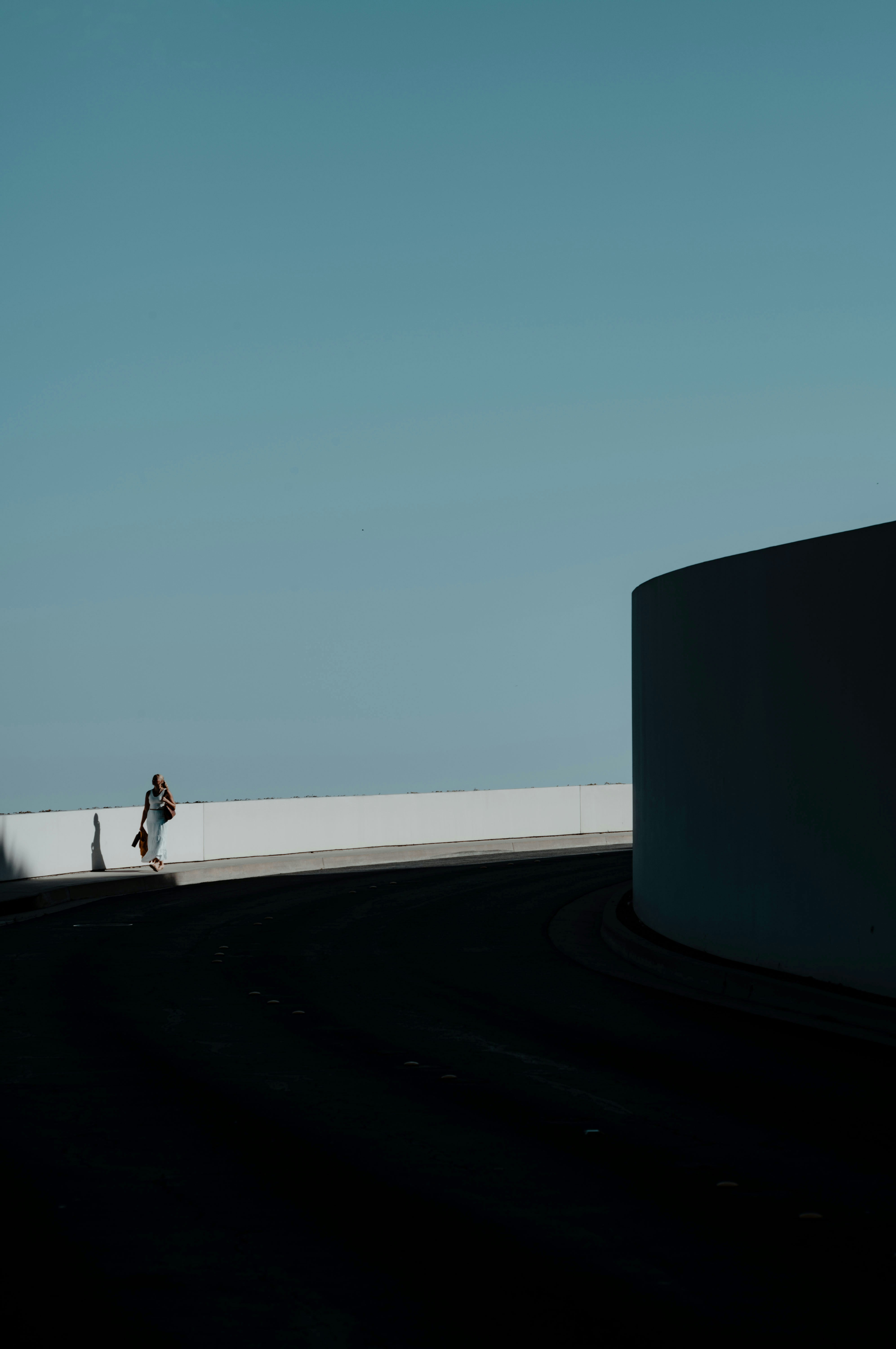 Lone Runner on the Curved Path: A Quiet Moment Under Blue Skies