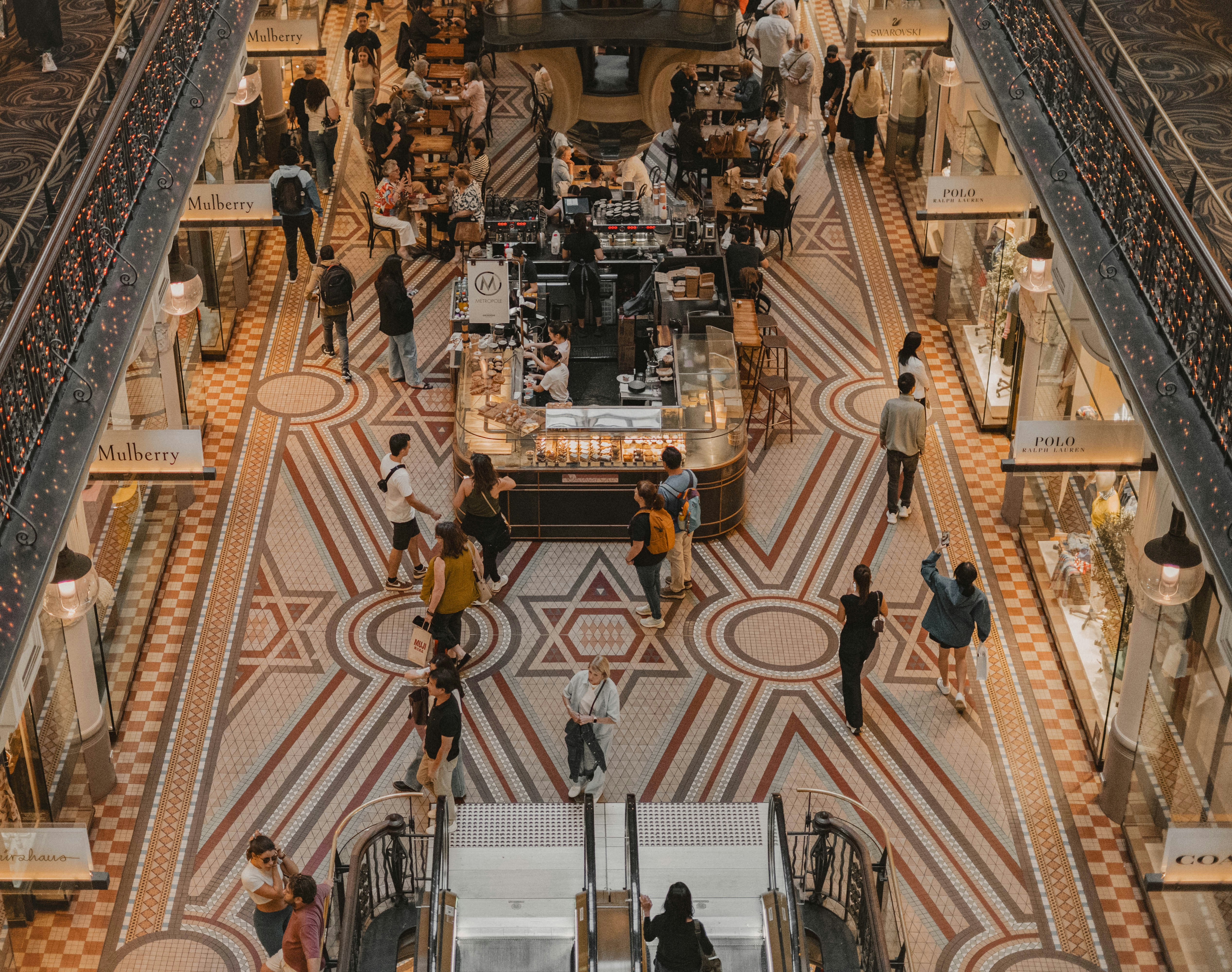 Atrium Mosaic: Shoppers Drift Across a Geometric Mall Floor