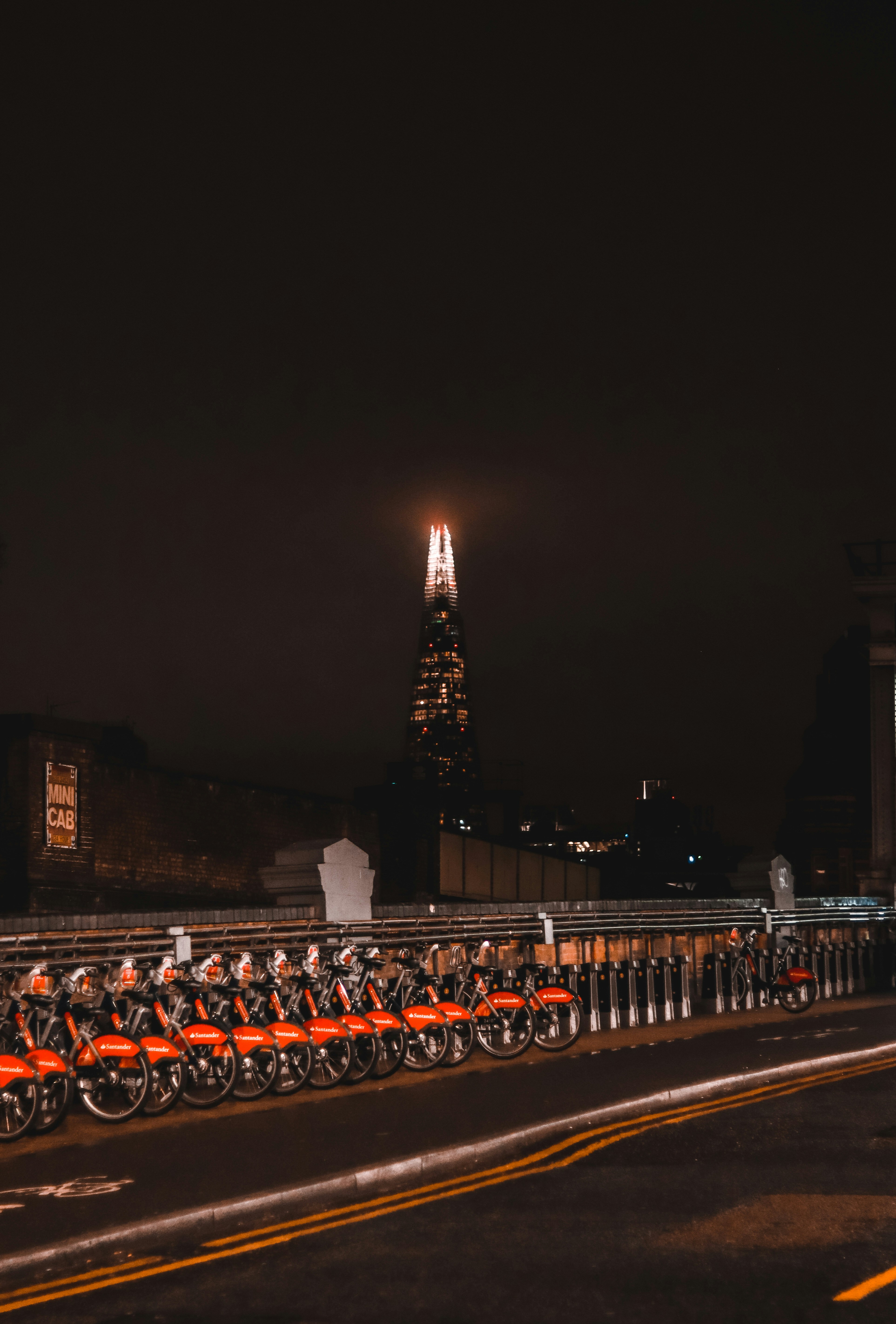 Midnight Lineup: Red Bikes Against a Skyline Tower