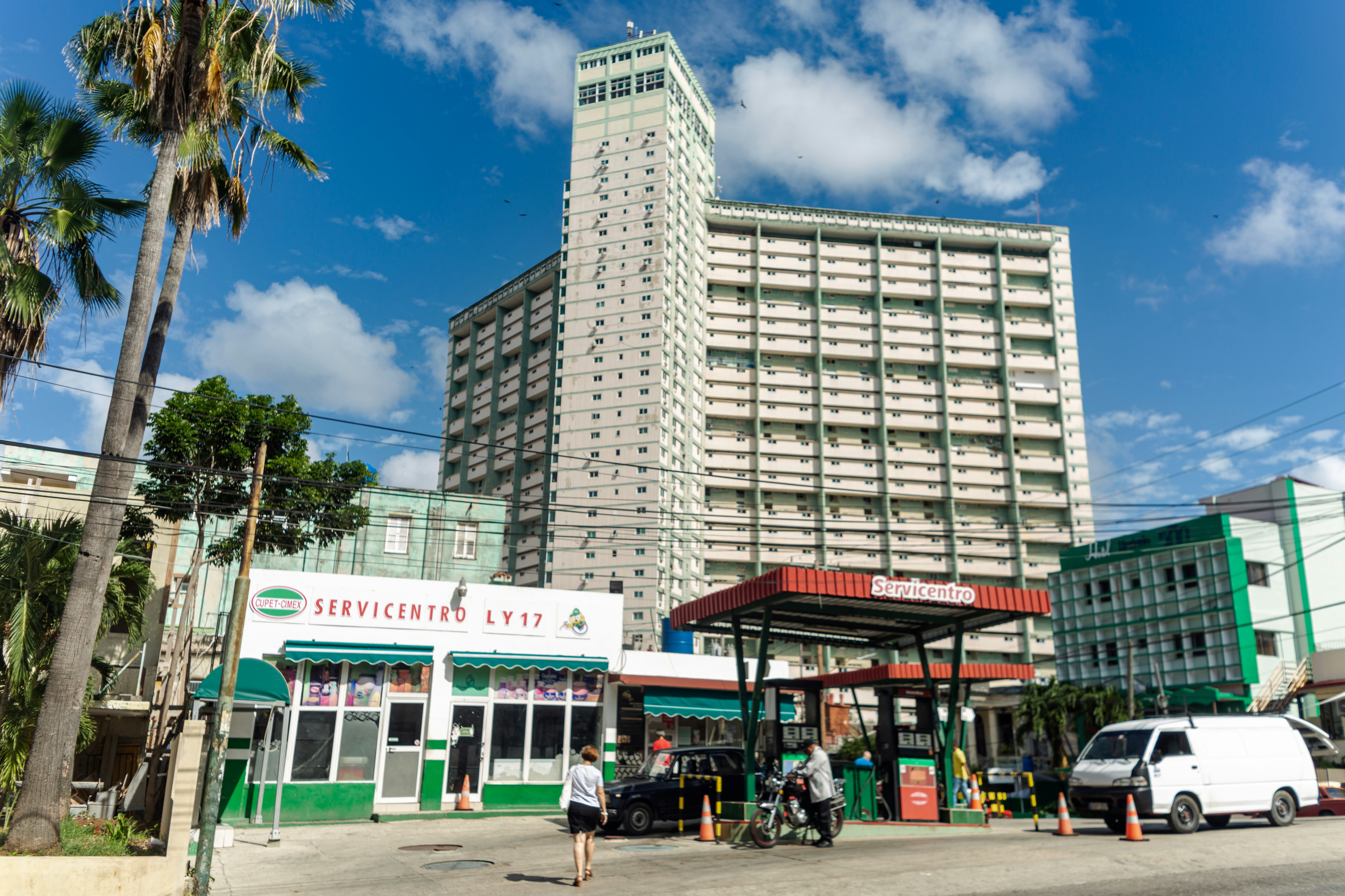 Sunlit Cityfront: Palm Trees, Bus Stop, and a Towering Centerpiece