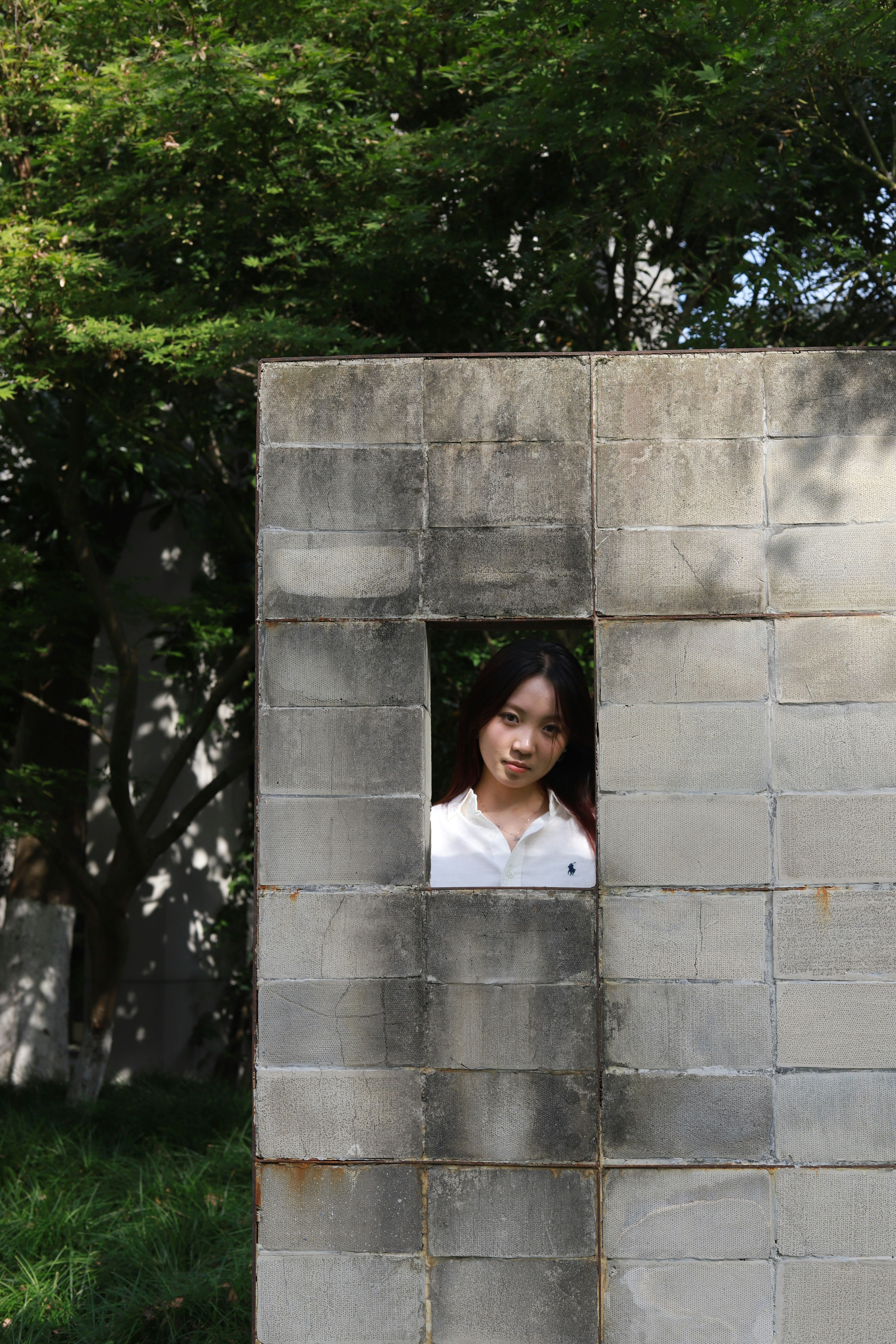 Through the Block Window: A Quiet Portrait Framed by Concrete Geometry