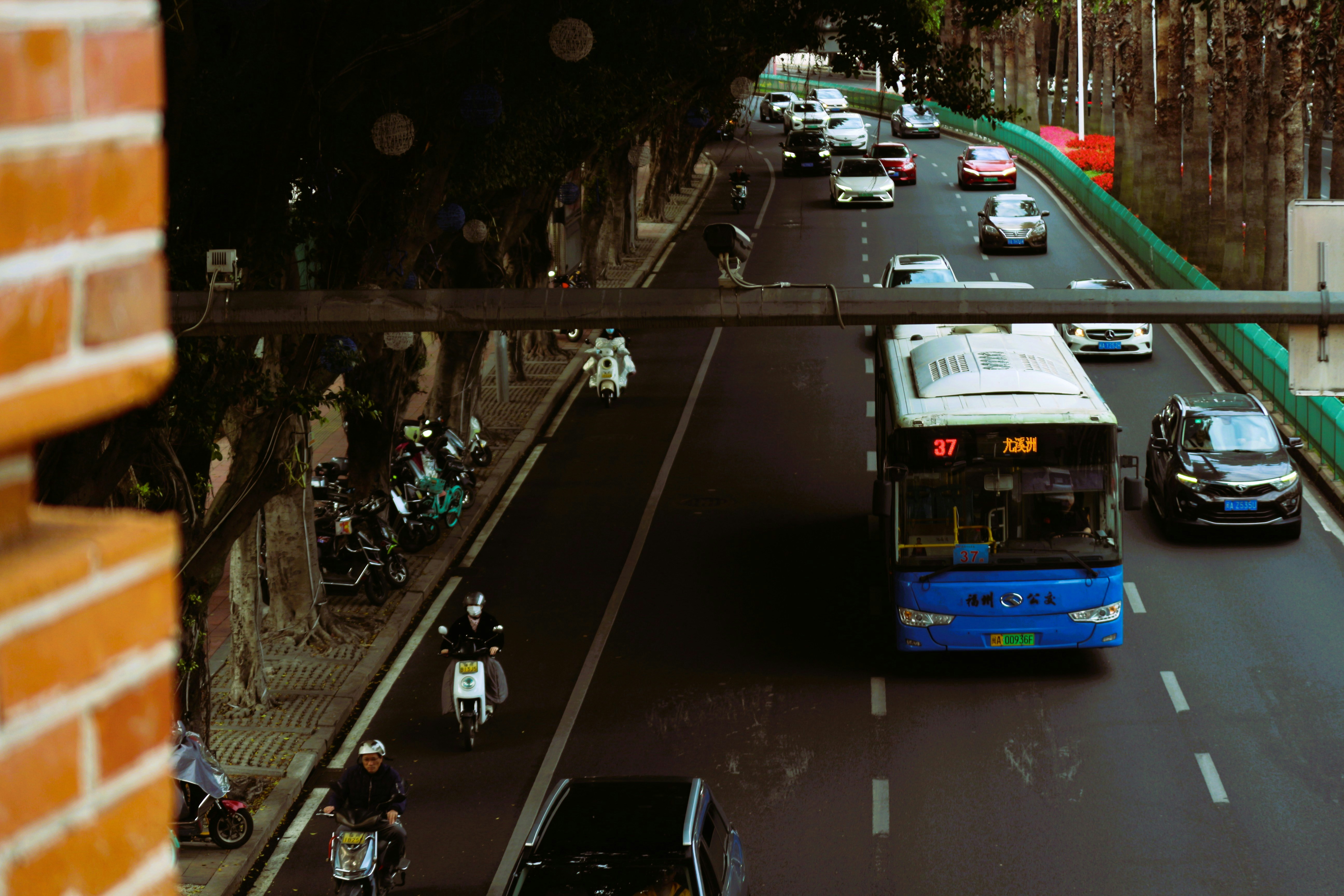 Traffic on a busy city road with cars and motorcycles.