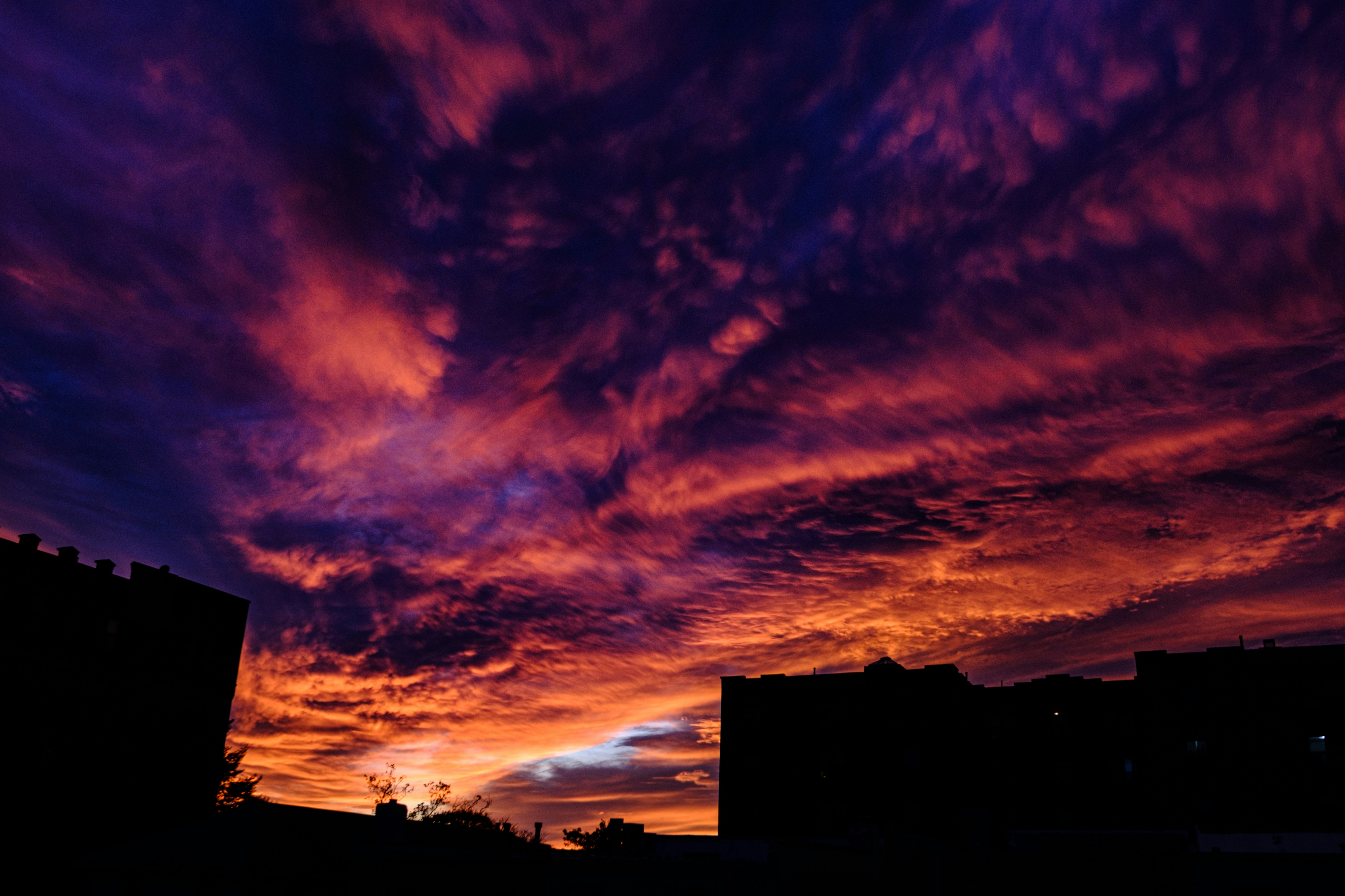 Tangerine Clouds Over a Silhouetted City at Dusk