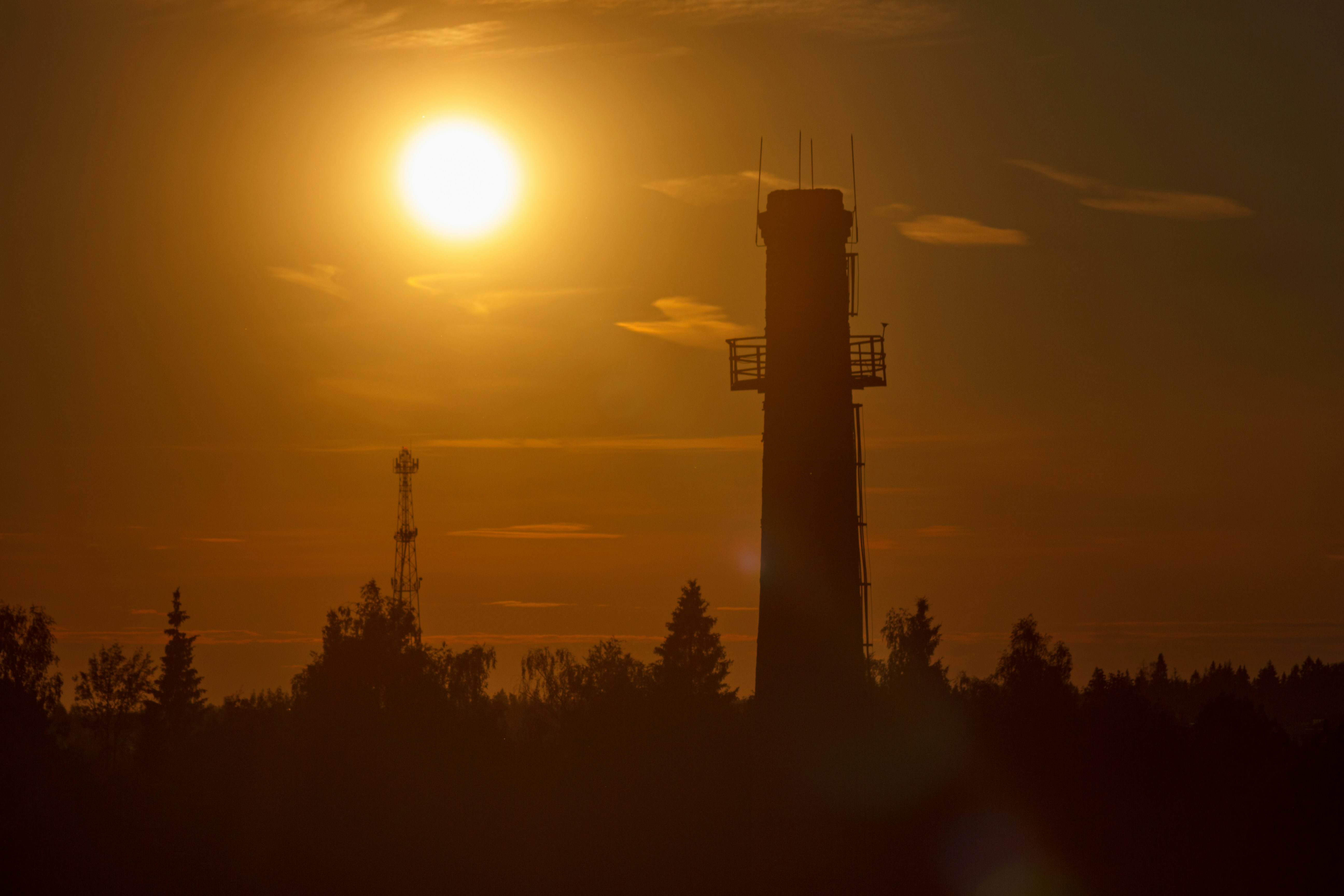 Solar Beacon over the Horizon: Silhouette of a Tower at Dusk