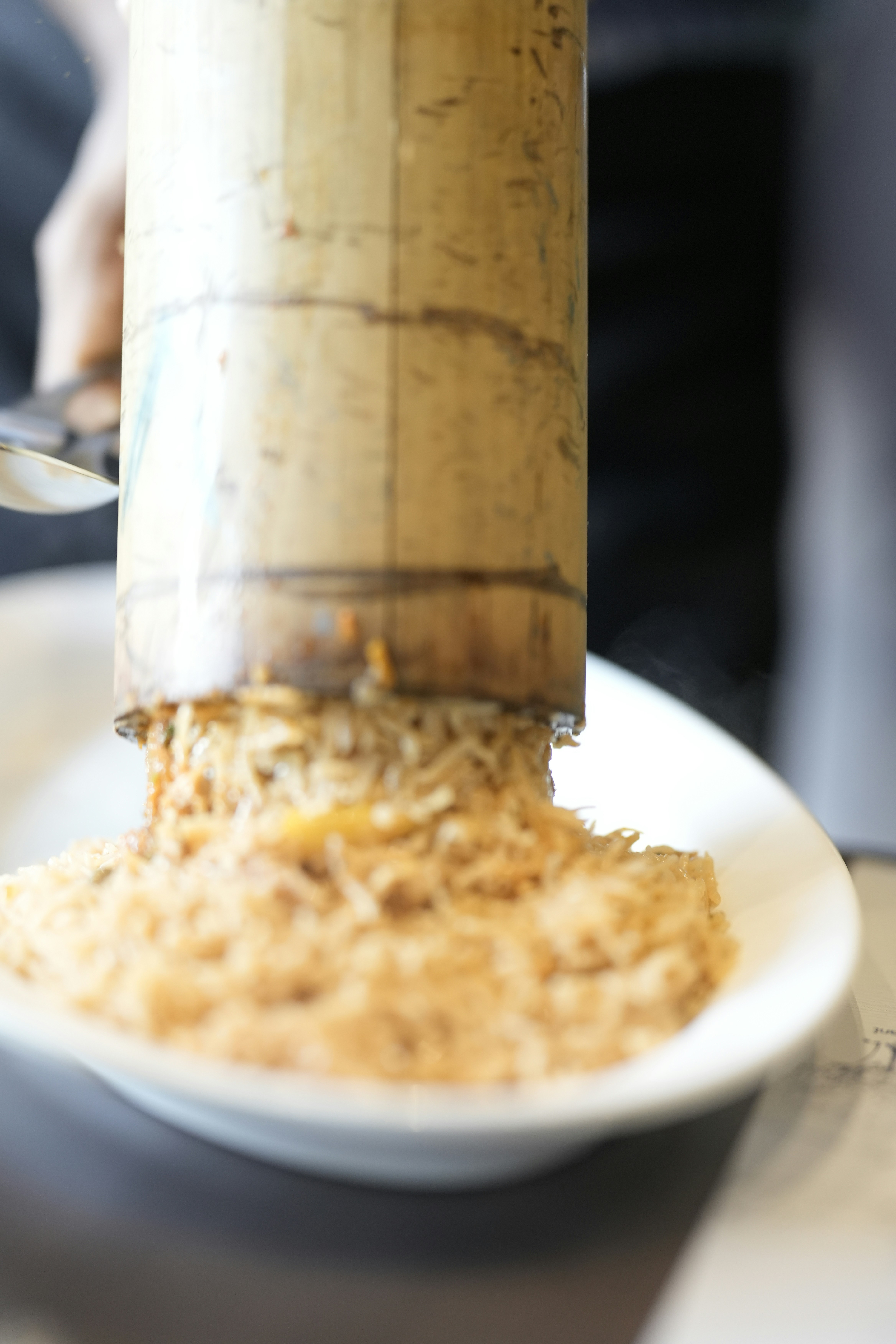 Vertical Bamboo Tube Over Toasted Toppings: A Macro Study in Texture and Depth