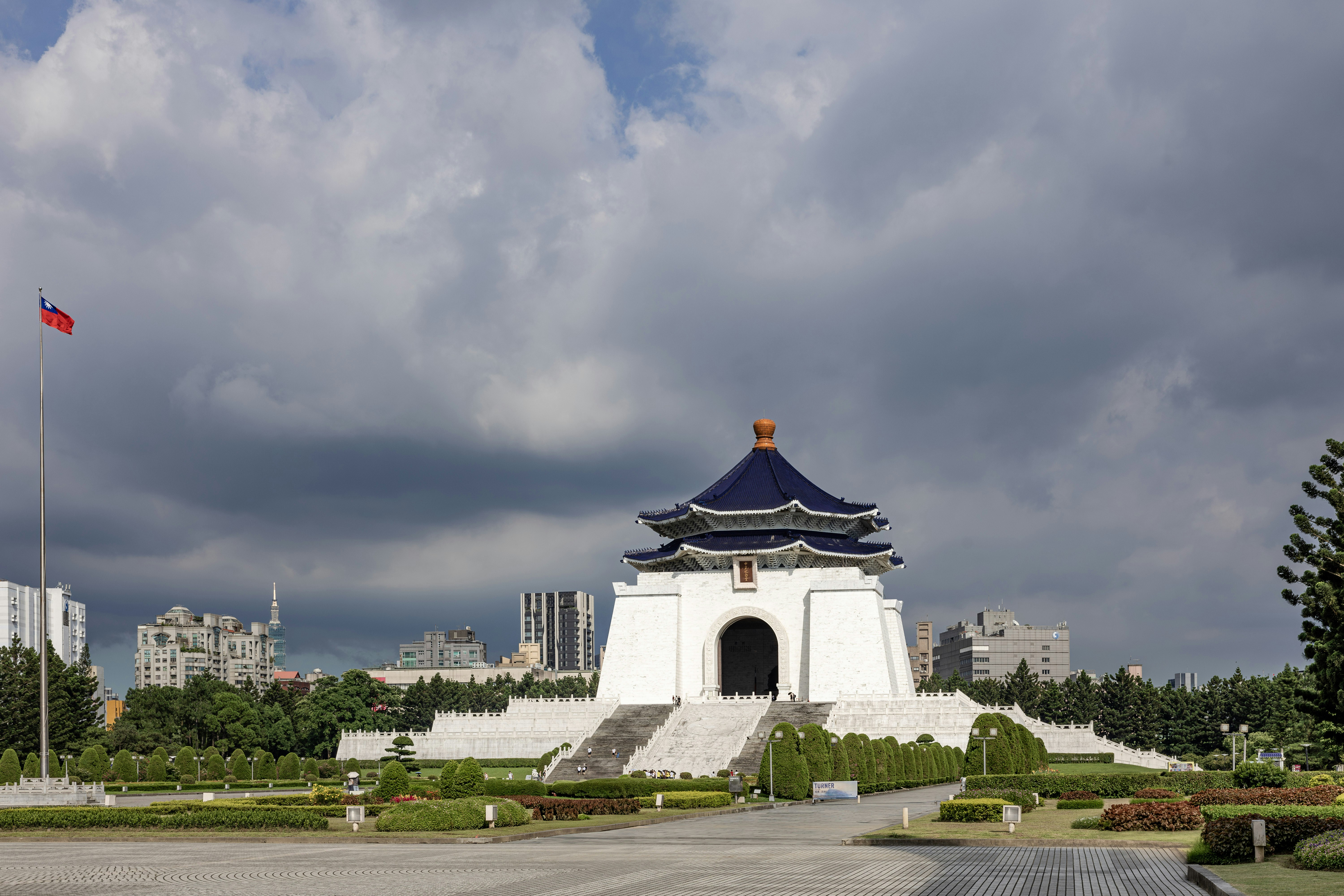 Central White Gate in a City Plaza Under Looming Cloudscape