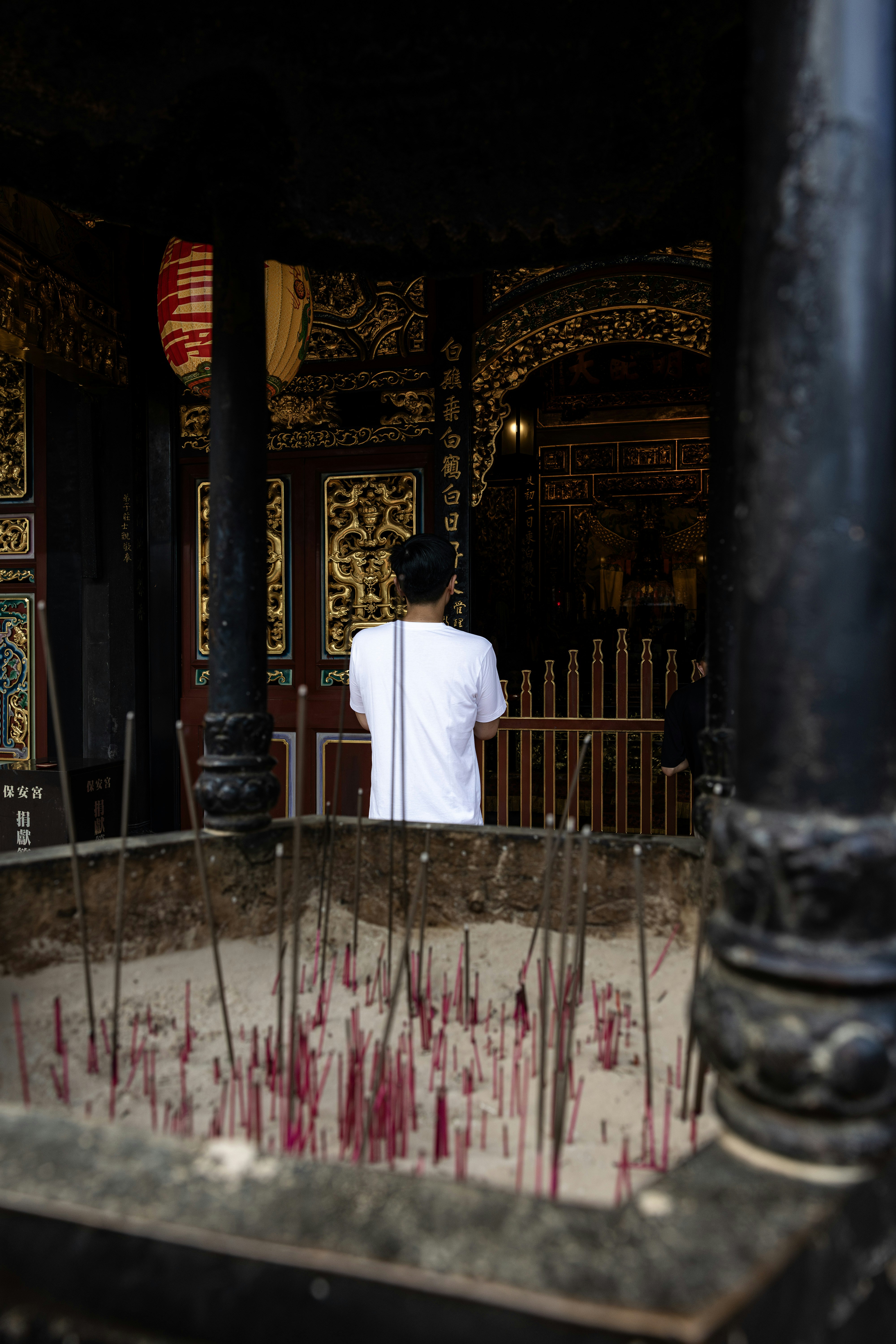 Man praying inside a temple with incense sticks