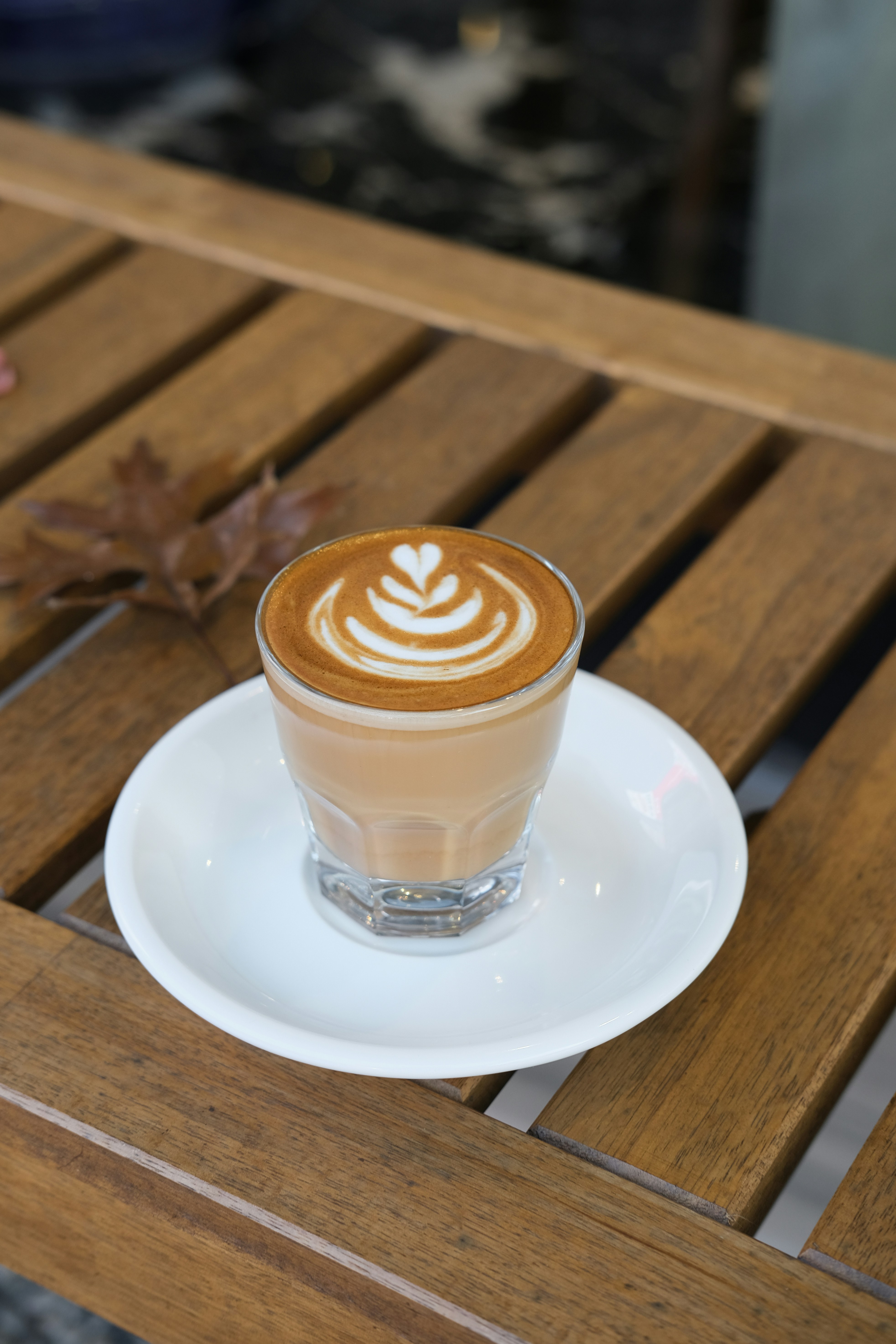 Rosette in Glass: Latte Art on a Sunlit Wooden Table