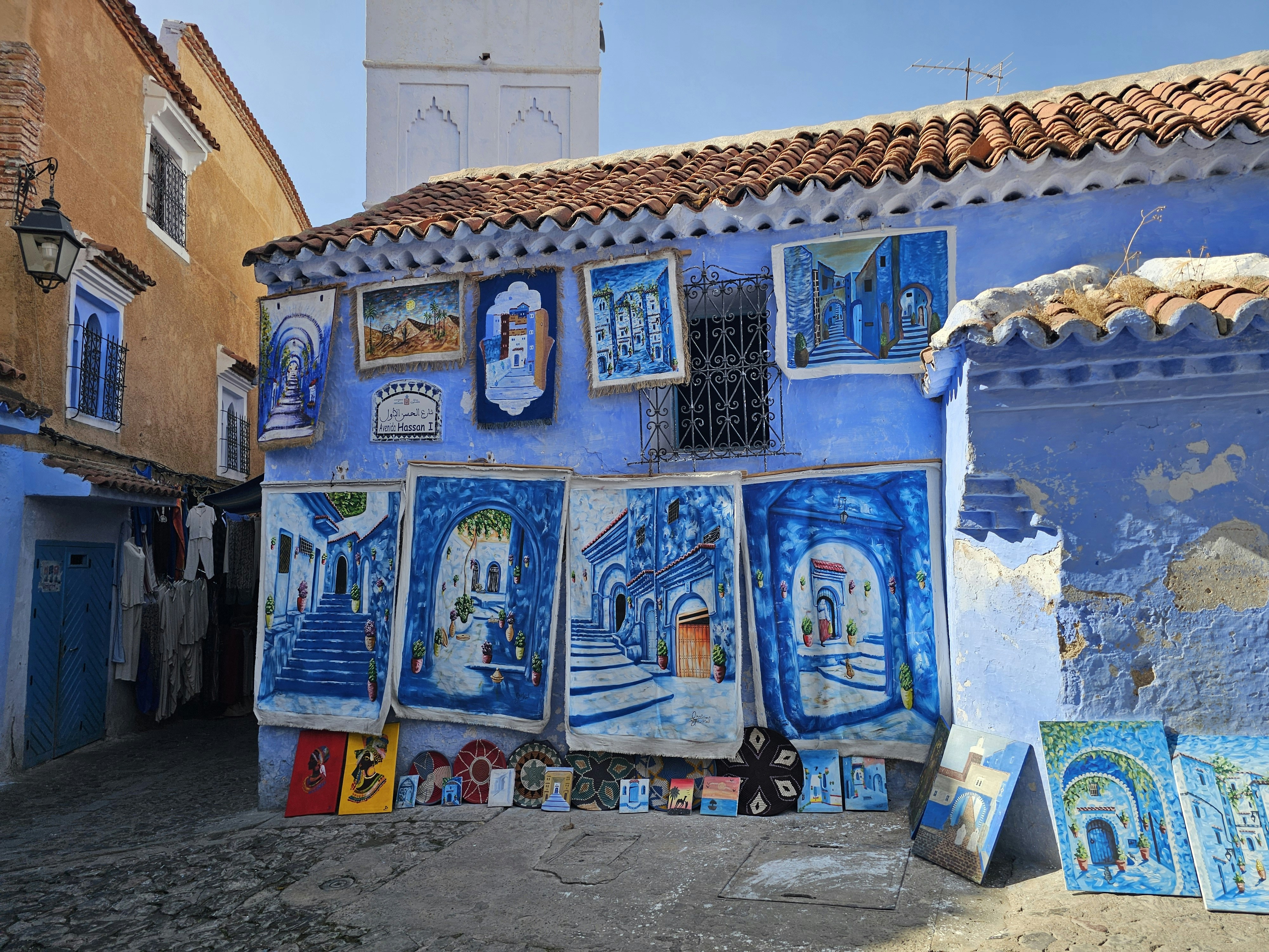 Azure Alley Gallery: Framed Paintings Lean Against a Blue Moroccan Wall