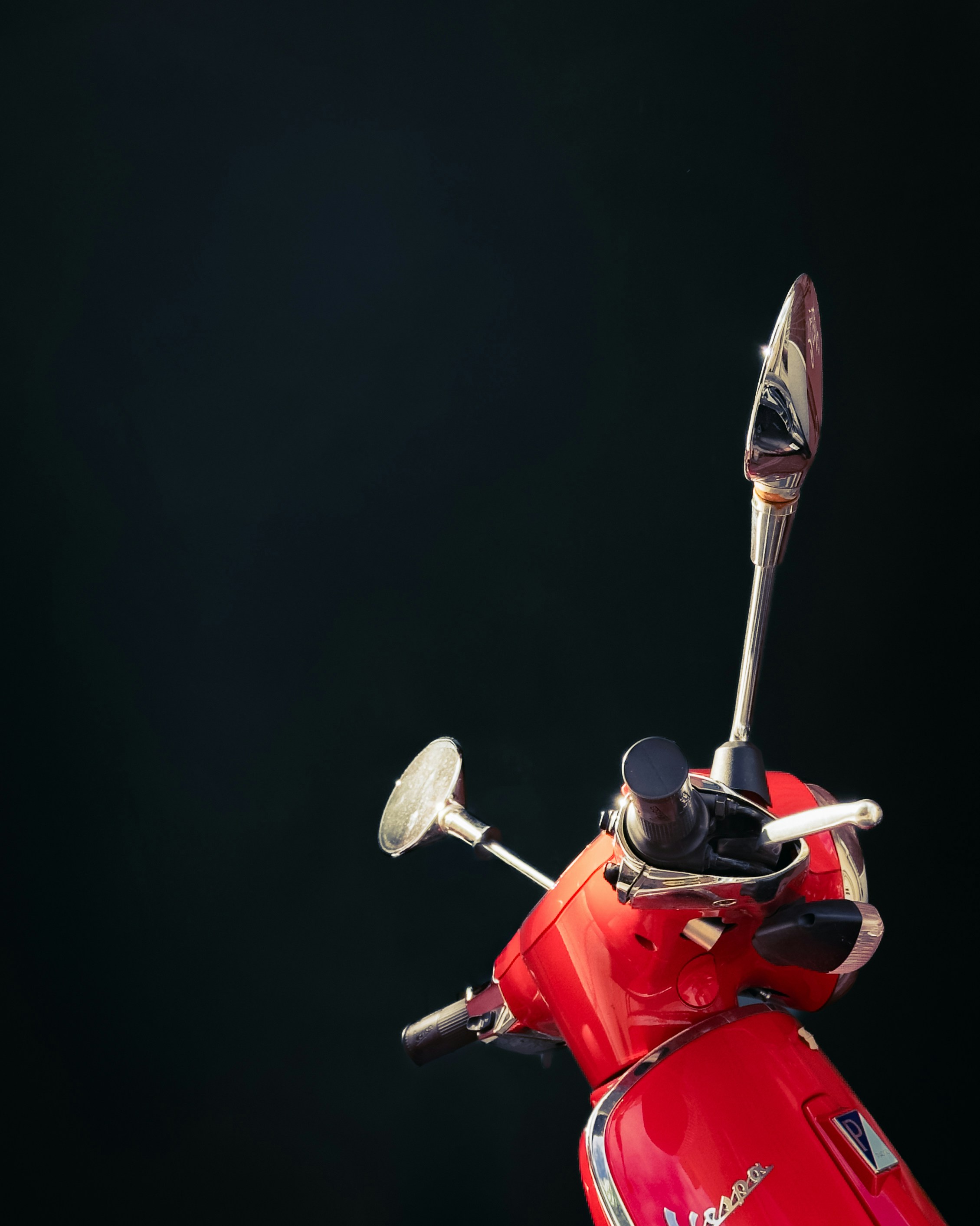 Crimson Vespa Gleam Against Velvet Darkness