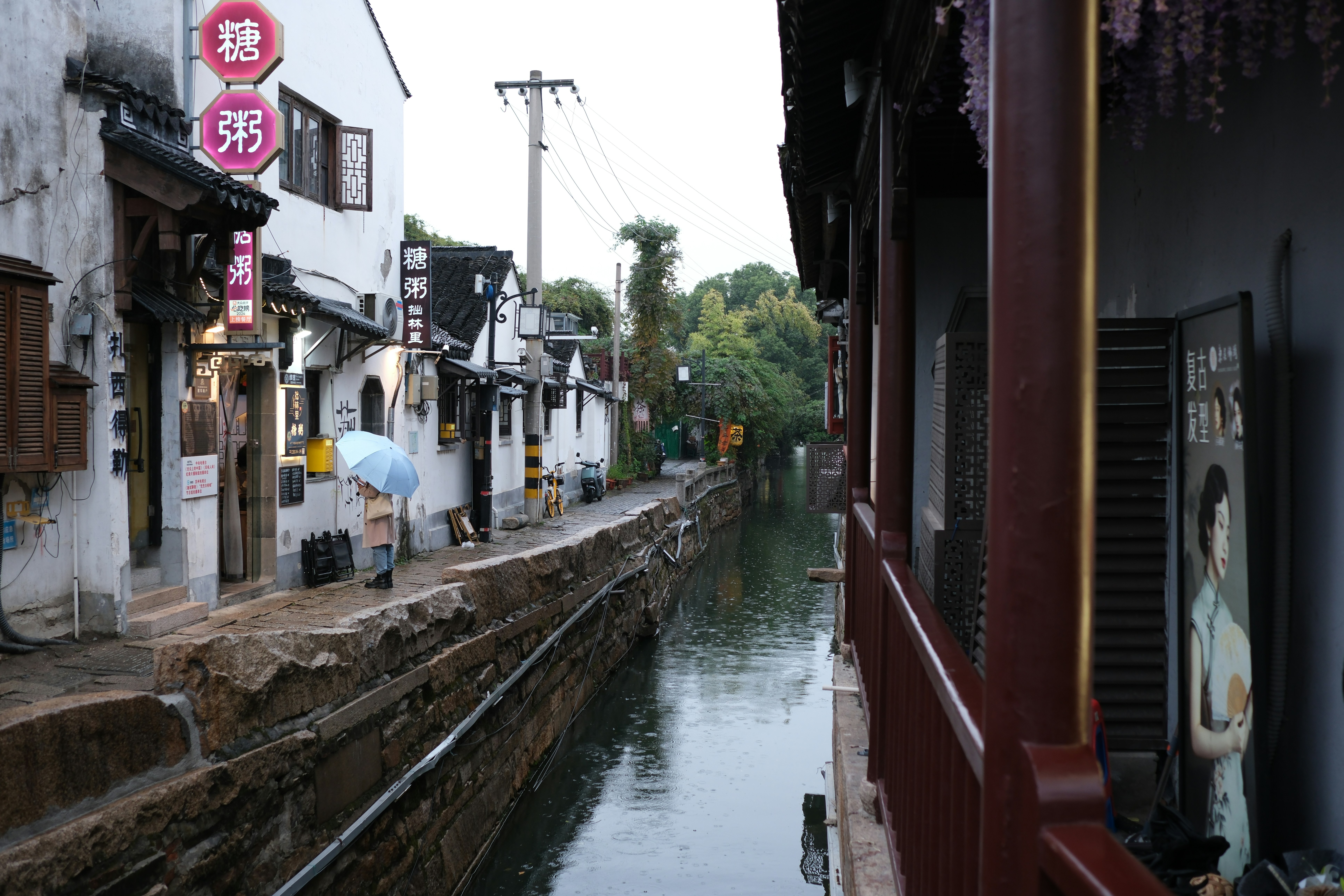 Blue Umbrella on the Lantern-Lined Canal Walk