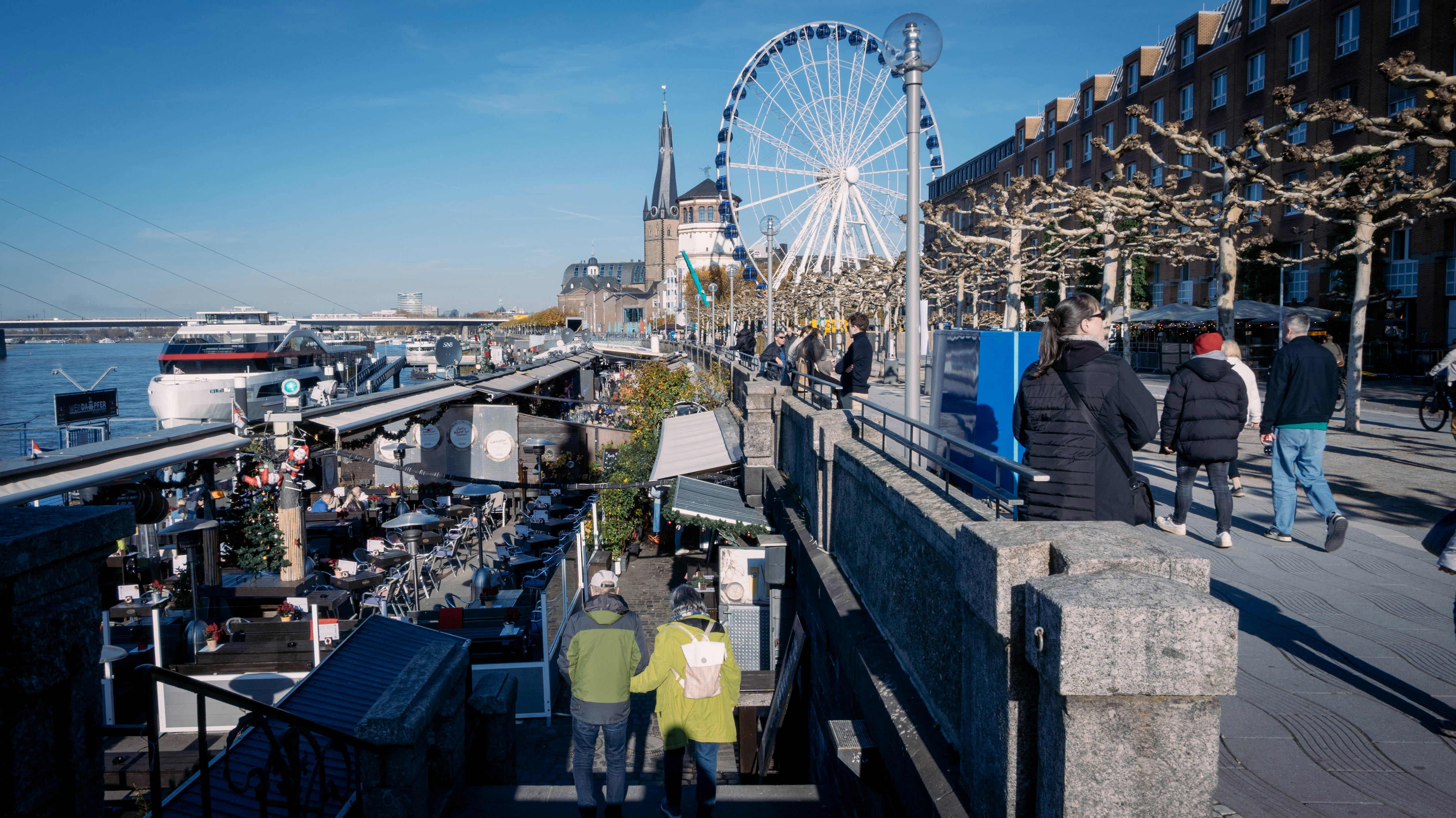 Harbor Promenade Under a Spinning Ferris Wheel Amid Waterfront Life