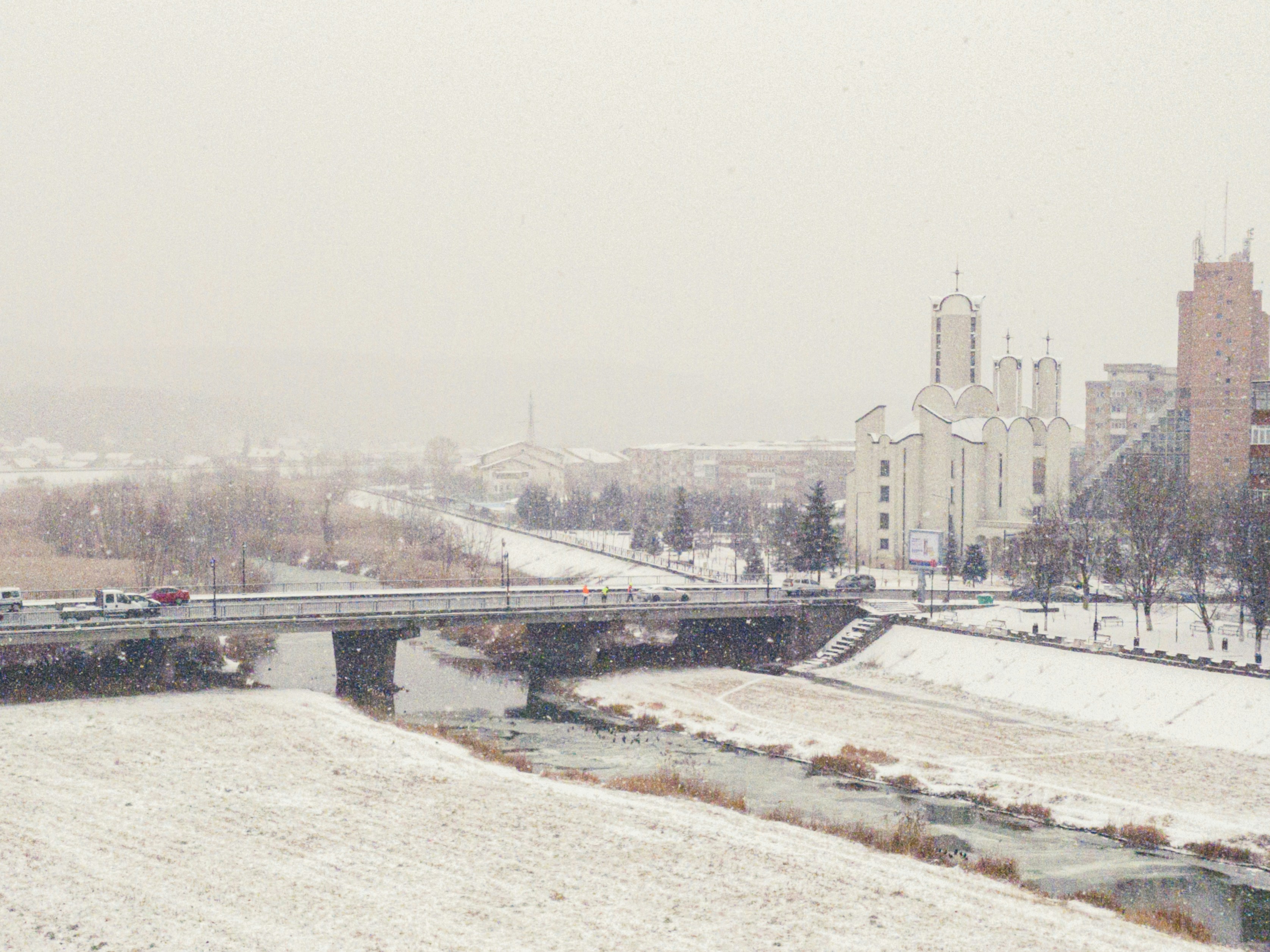 Snowbound River Verge: Bridges and Silos Amid Quiet Winter