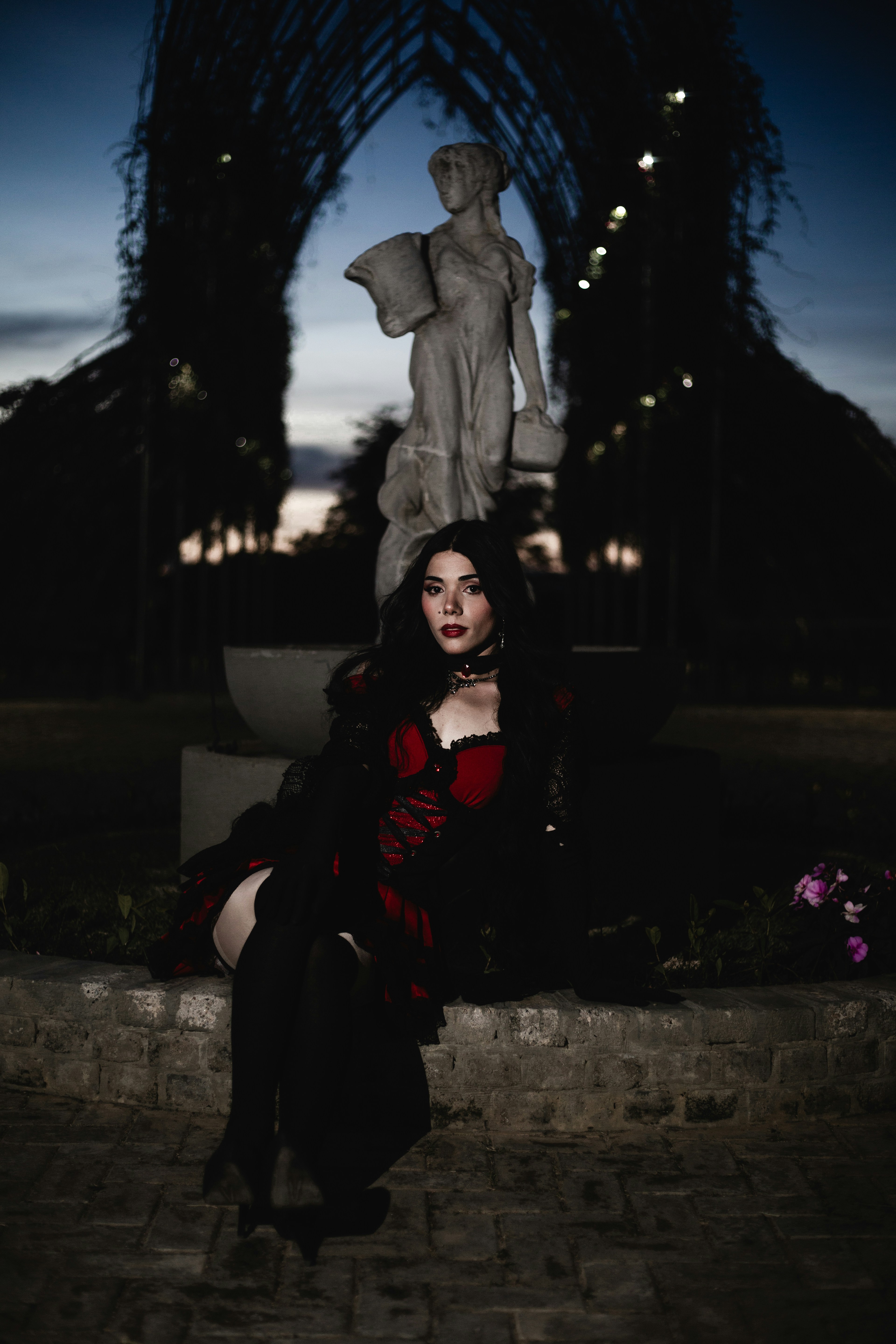 Nocturnal Velvet: Portrait by a Statue Under Lantern Arches