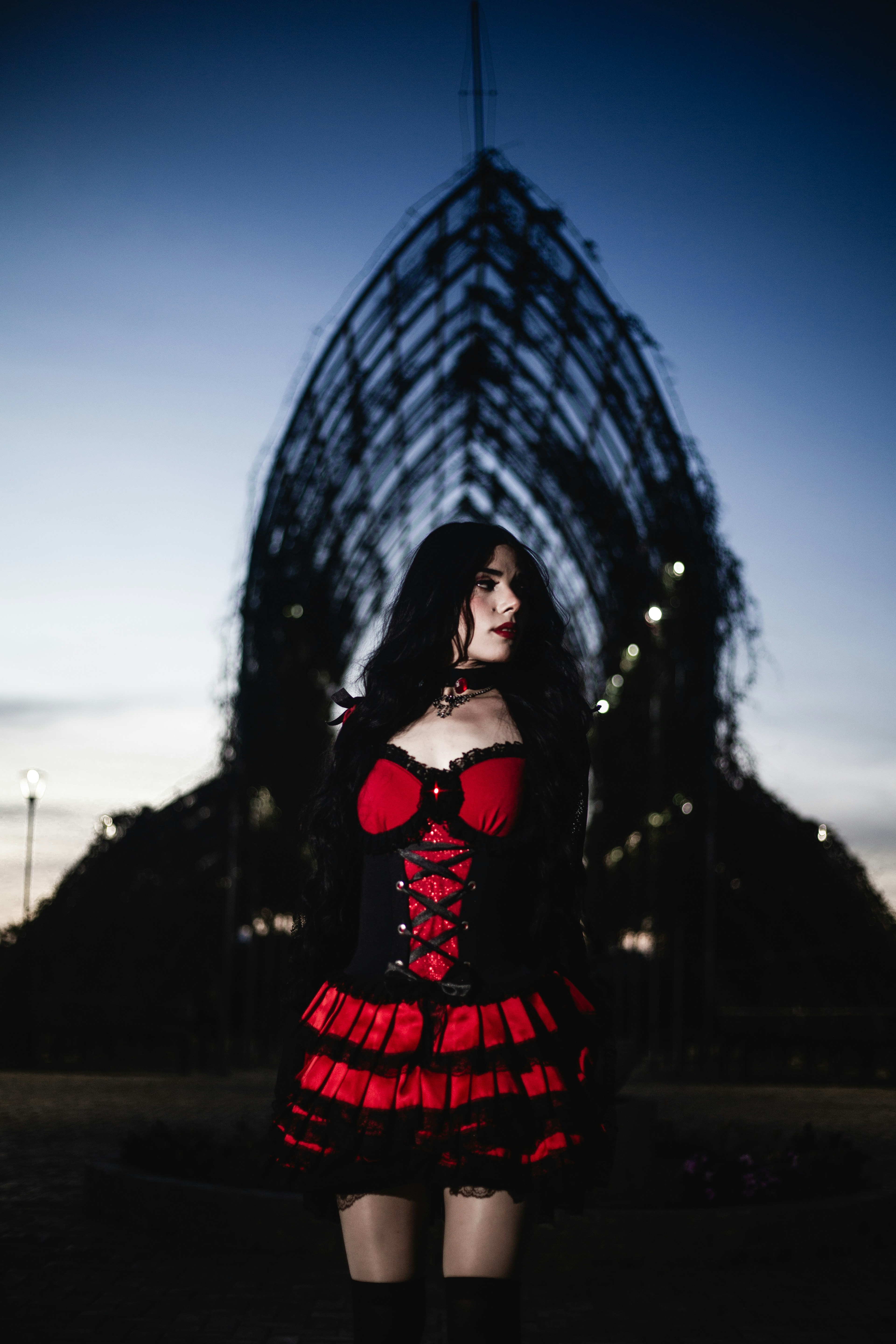 Midnight Couture: The Enigmatic Red-Black Ensemble at the Skeleton Arch