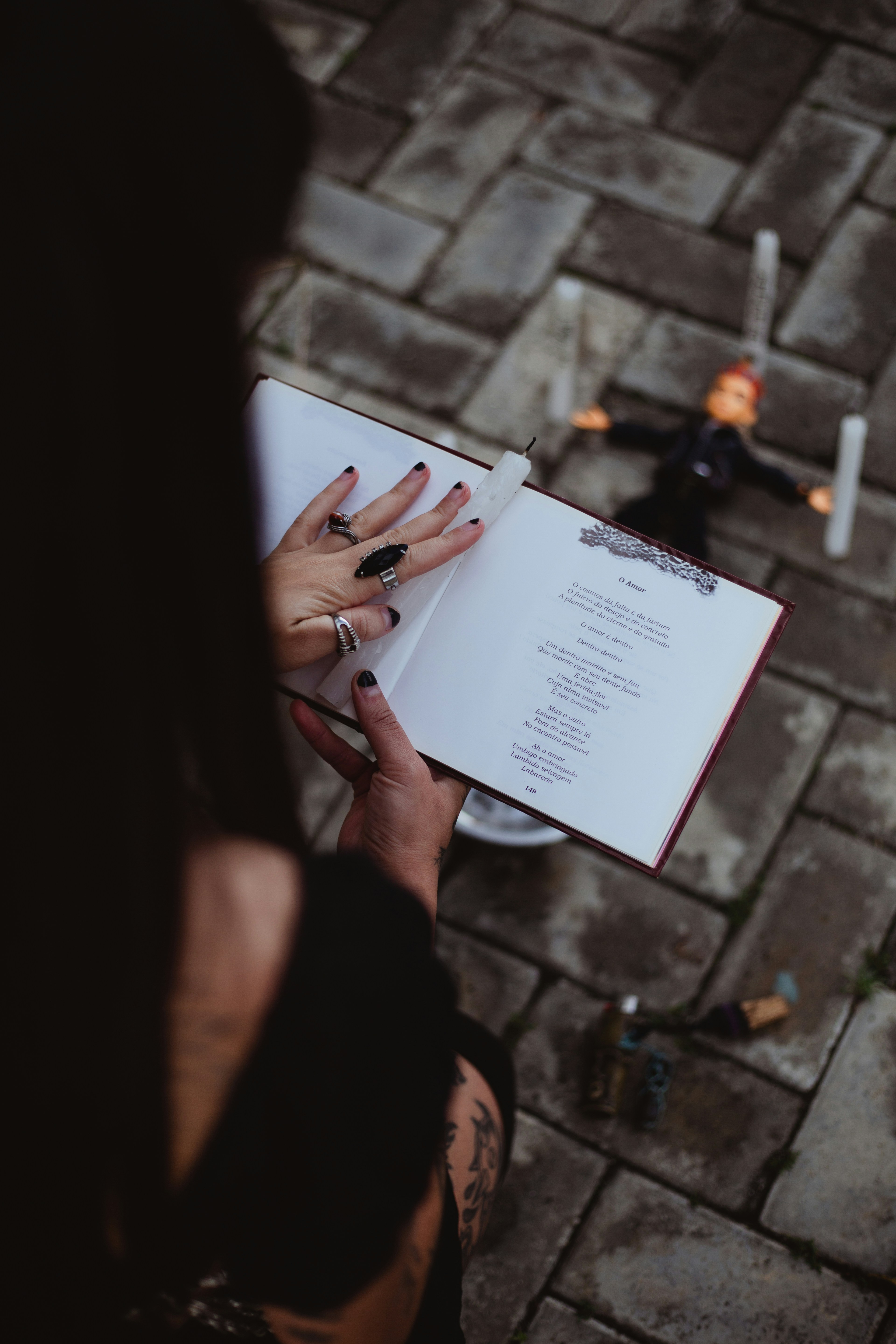 Ink and Illumination: Hands Reading an Open Book on a Cobblestone Stage