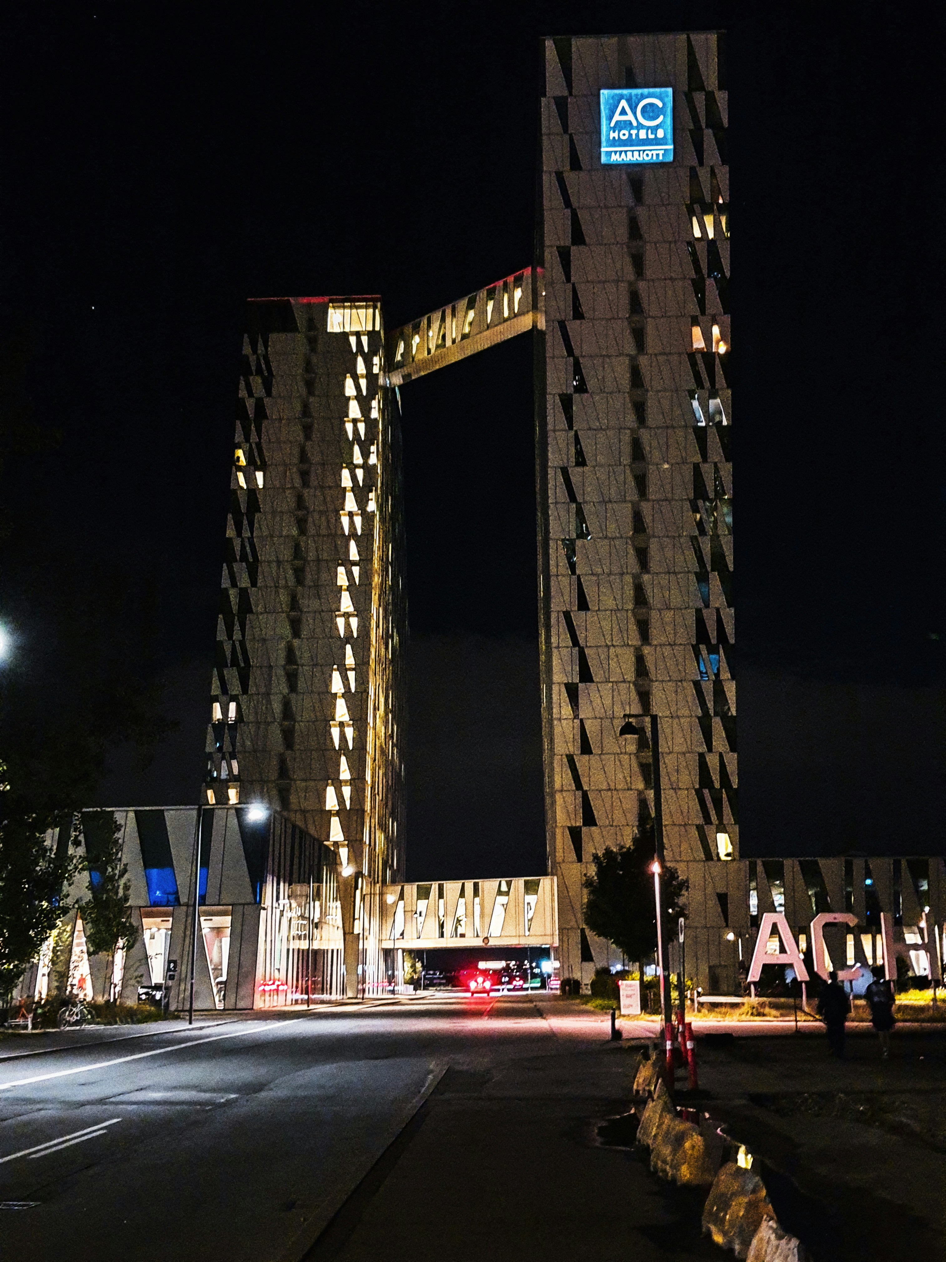 Modern hotel towers illuminated at night with skybridge connection ...