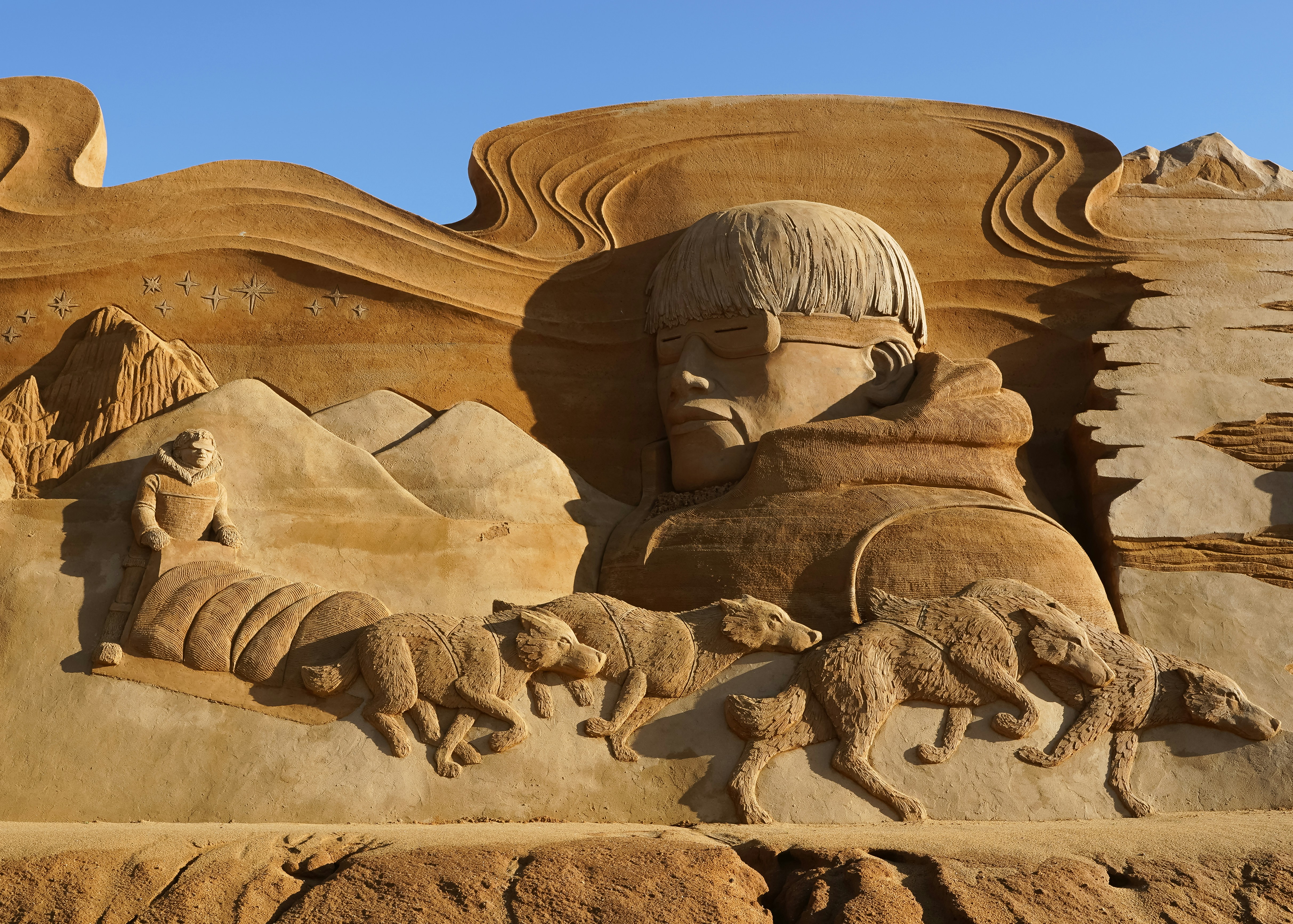The Sand Sentinel: Giant Bust Over a Parade of Carved Beasts