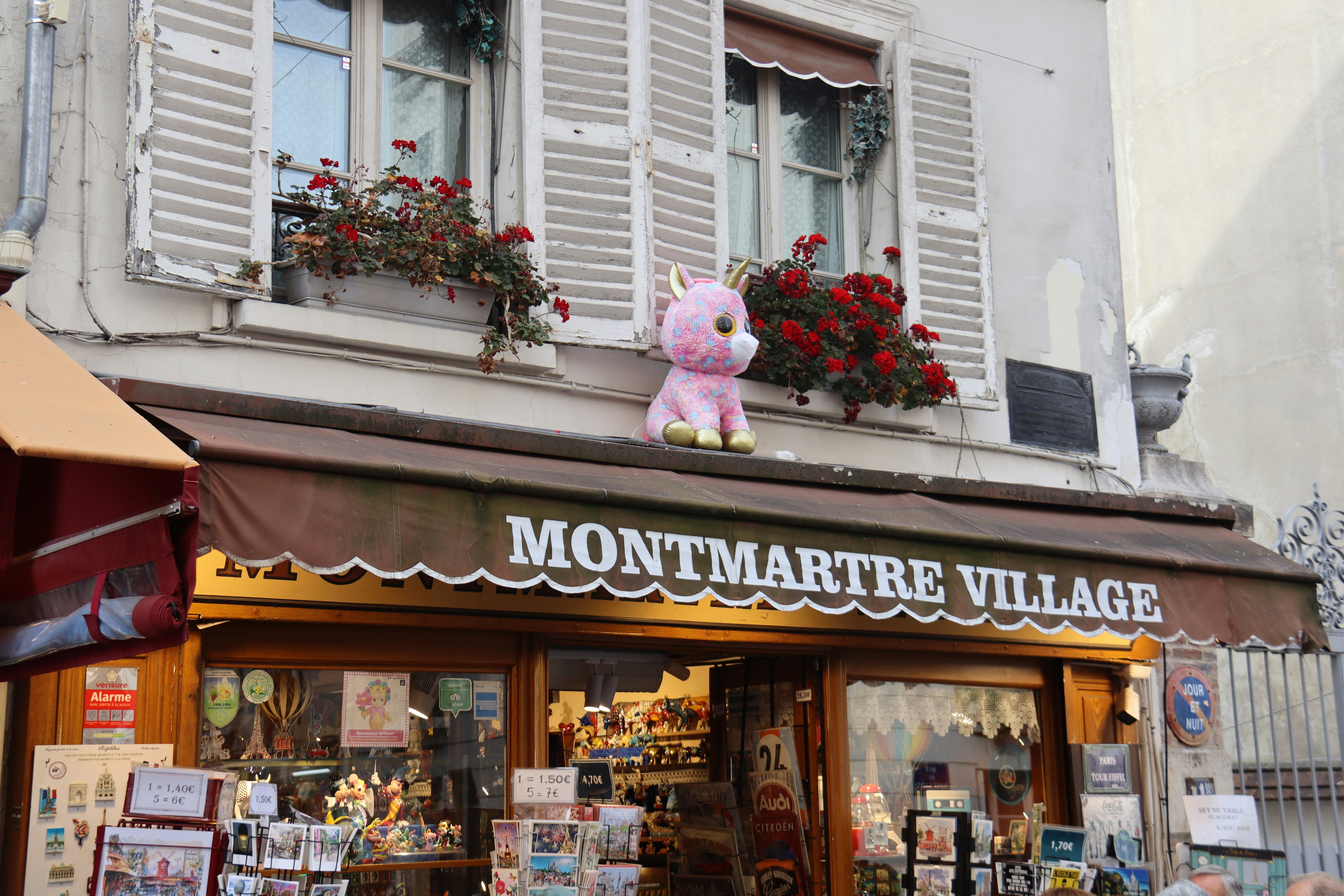 Pink stuffed animal sits above montmartre village shop. photo – Free ...