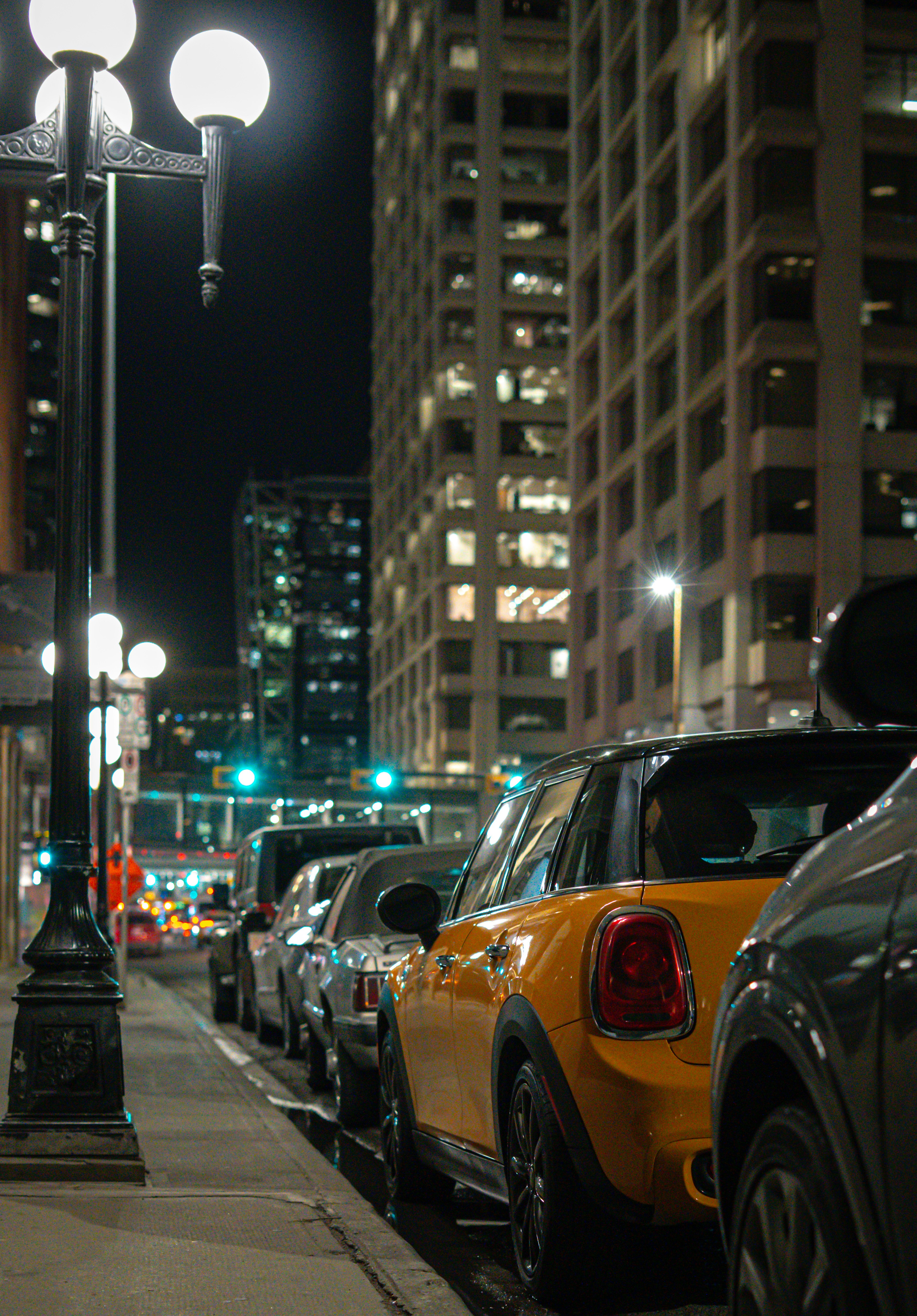 Yellow Mini Cooper Anchored by Lanterns on a Night Street