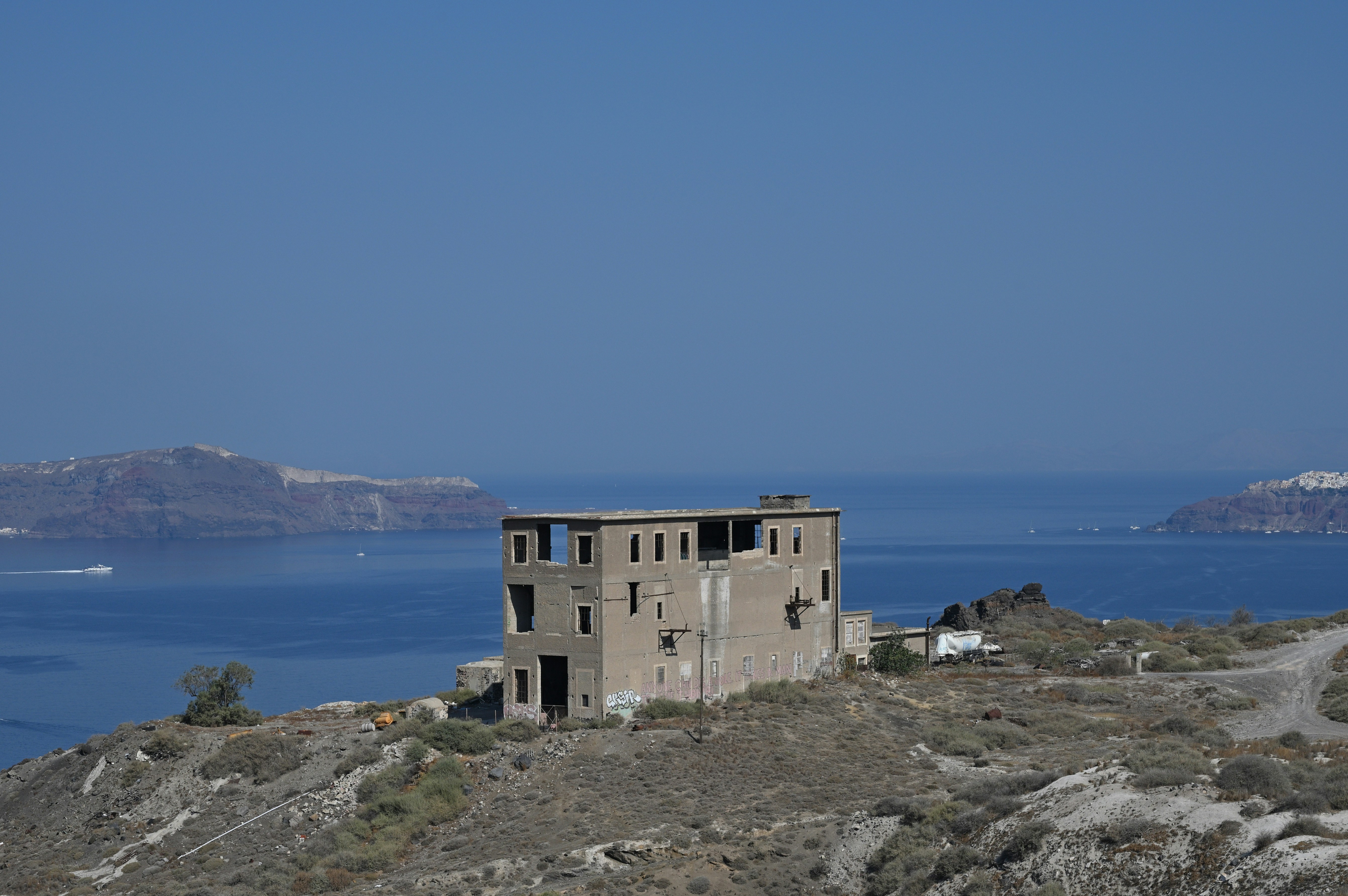 Weathered Seafront Ruin Amid Windswept Hills and a Calm Blue Horizon
