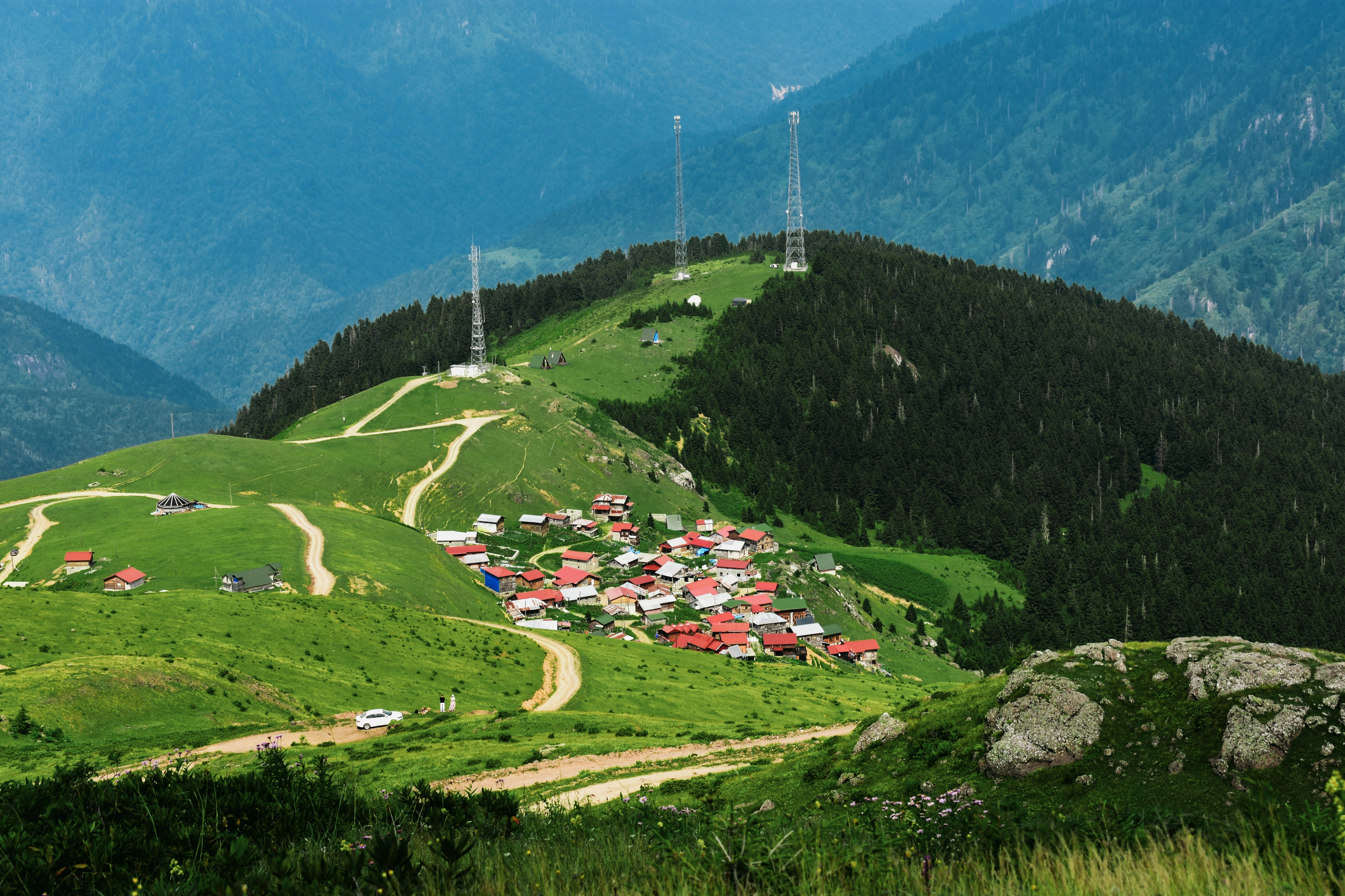 Red-roofed Hamlet on a grassy knoll beneath ridge-top towers