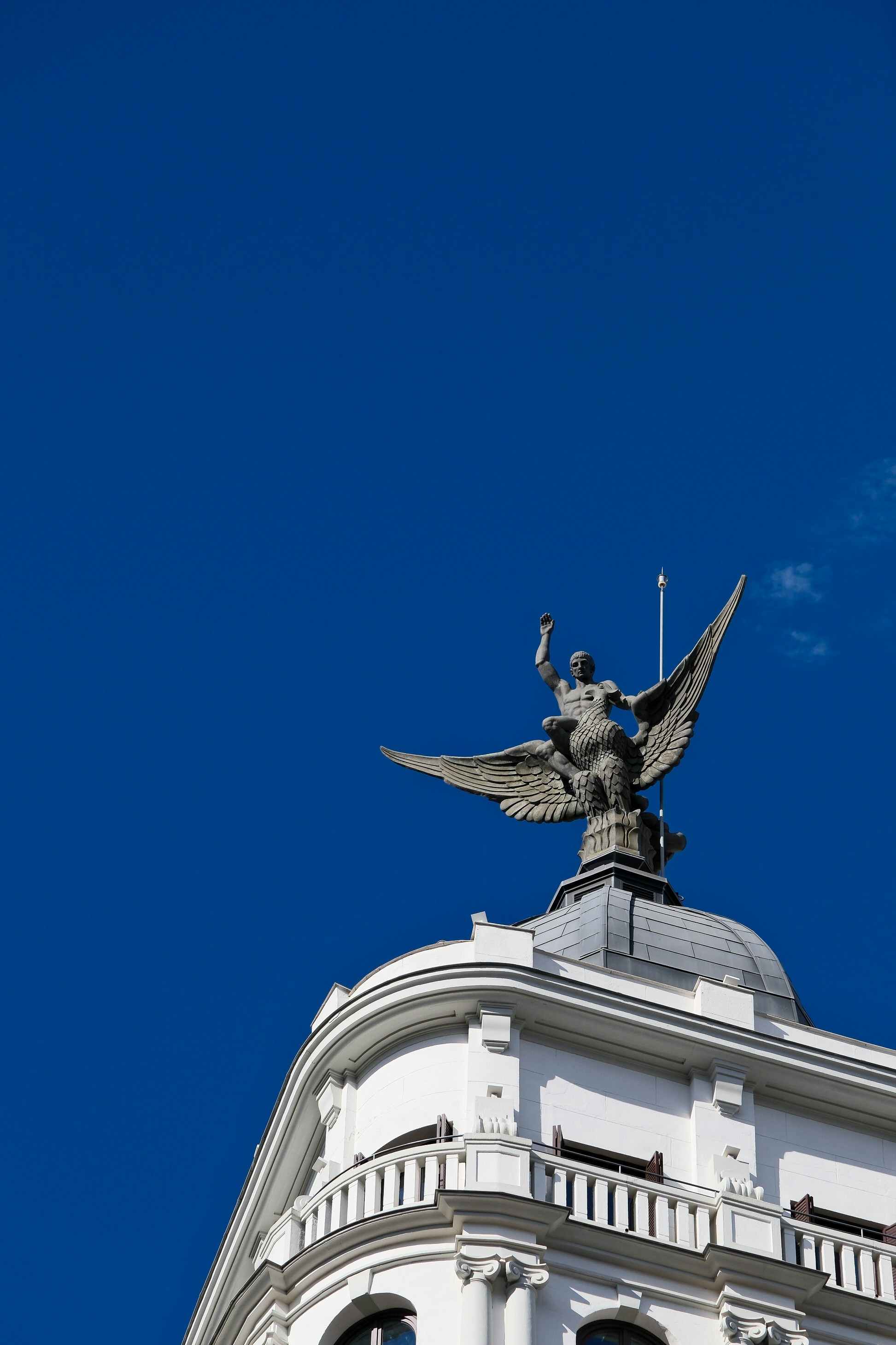 Winged Victory Above a Neoclassical Dome Against a Deep Azure Sky