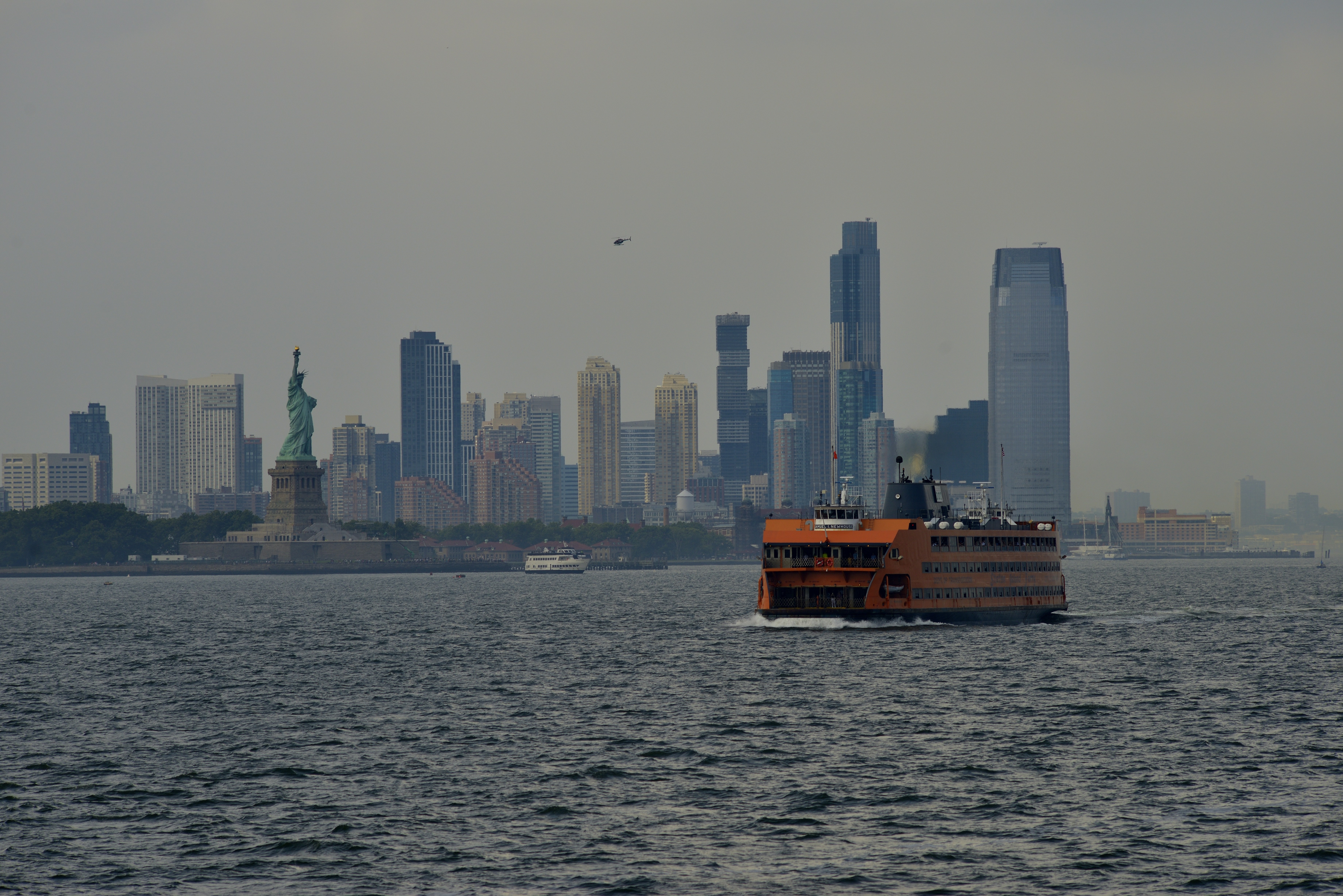 Orange Ferry Cutting Through the Harbor Toward the Skyline
