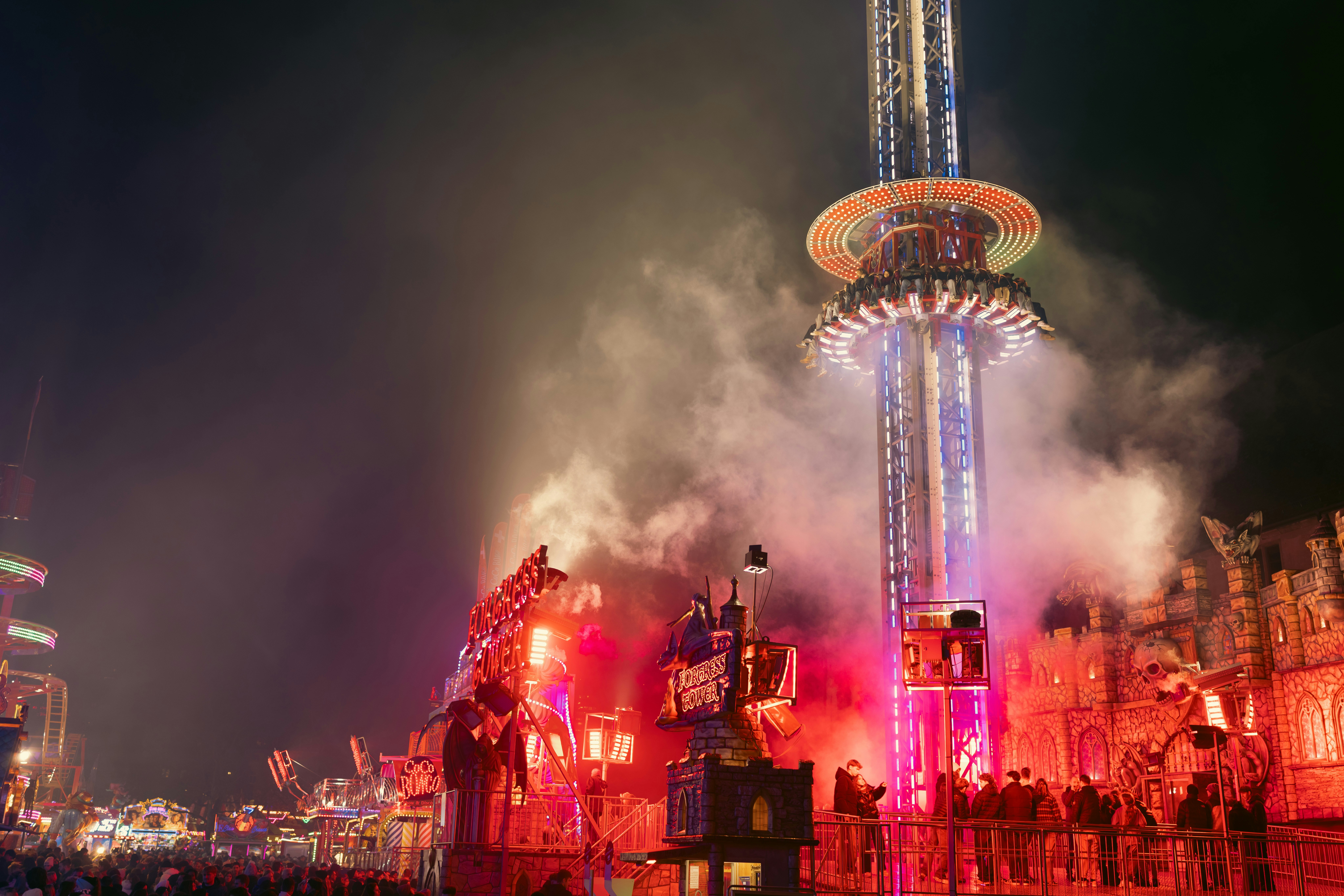 Ringed Tower Nights: Neon Fire and Fog Over the Carnival