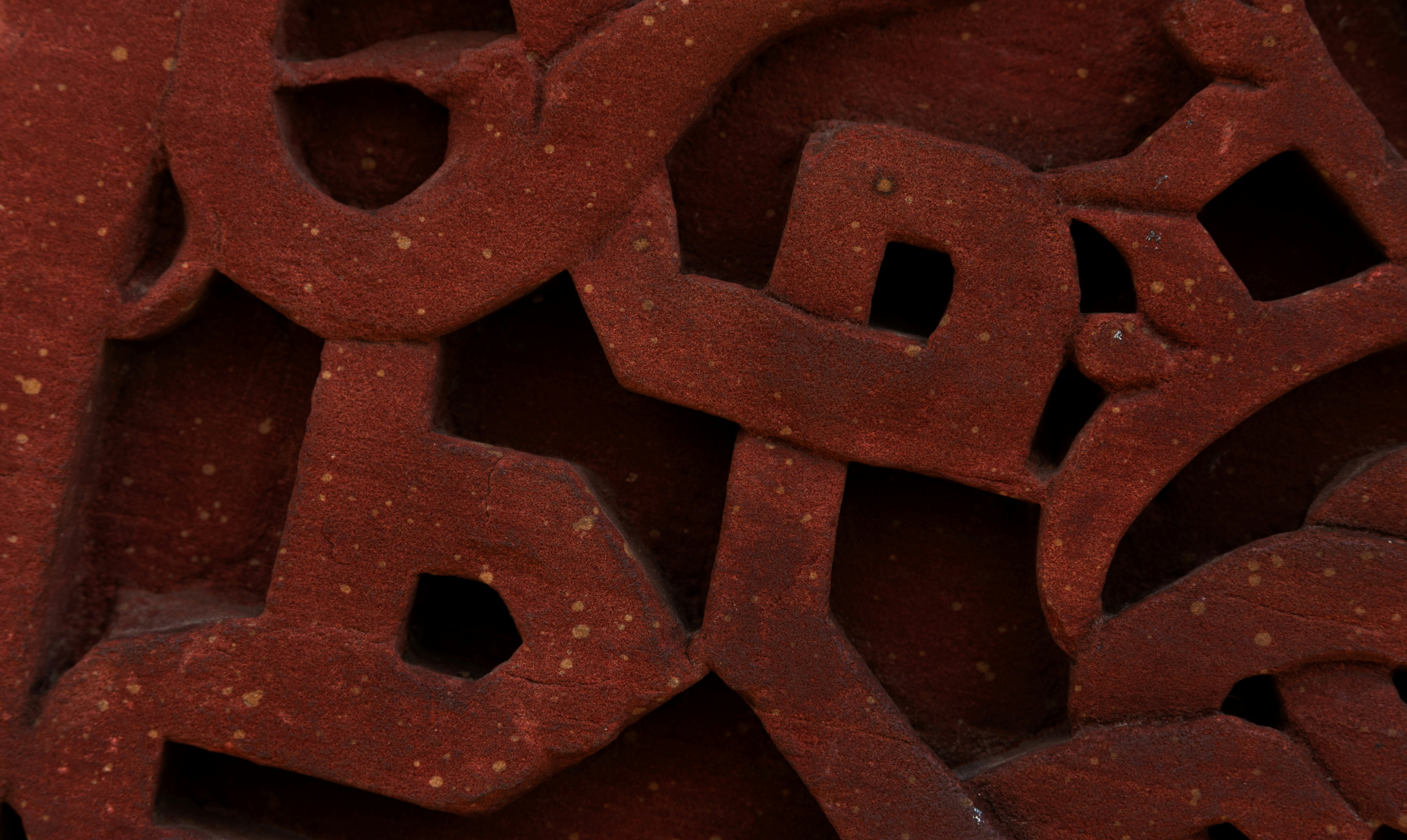 Crimson Rust: Close-up of Interlocking Metal Fragments in a Rusted Lattice
