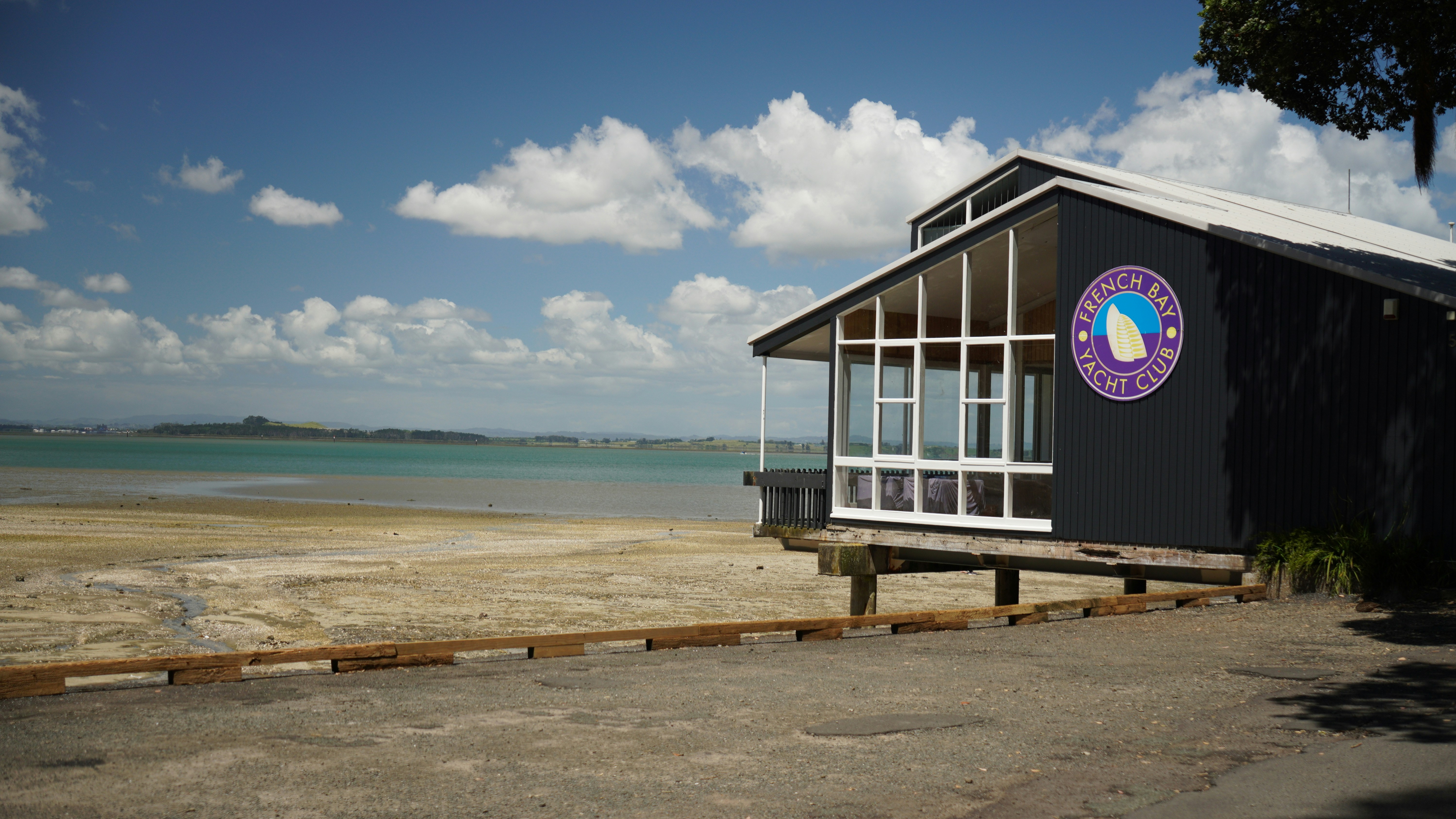 Sunlit Shack Beside a Calm Sea: A Beachfront Snapshot