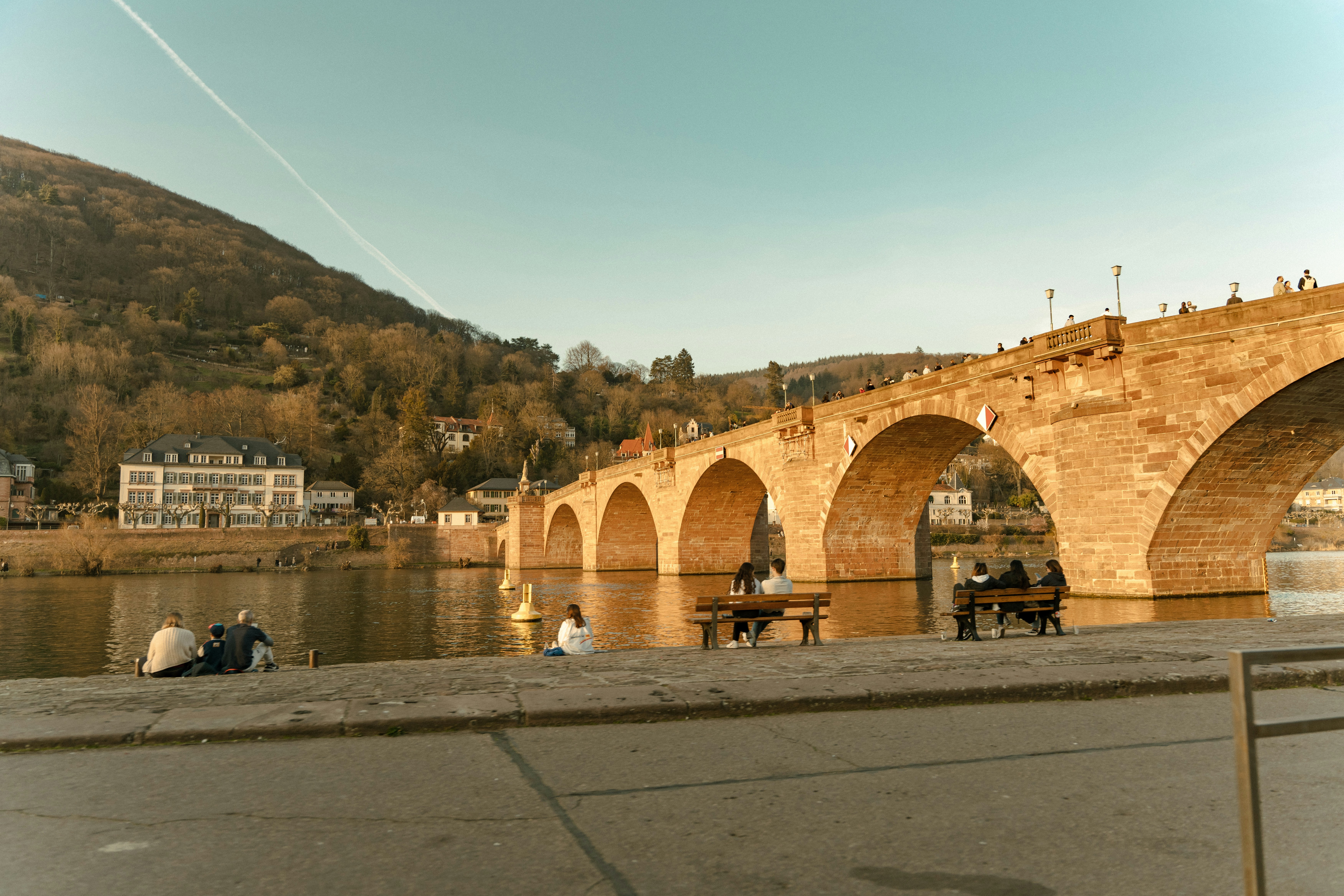 Sunlit Arches Over the River: Quiet Moments by the Bridge