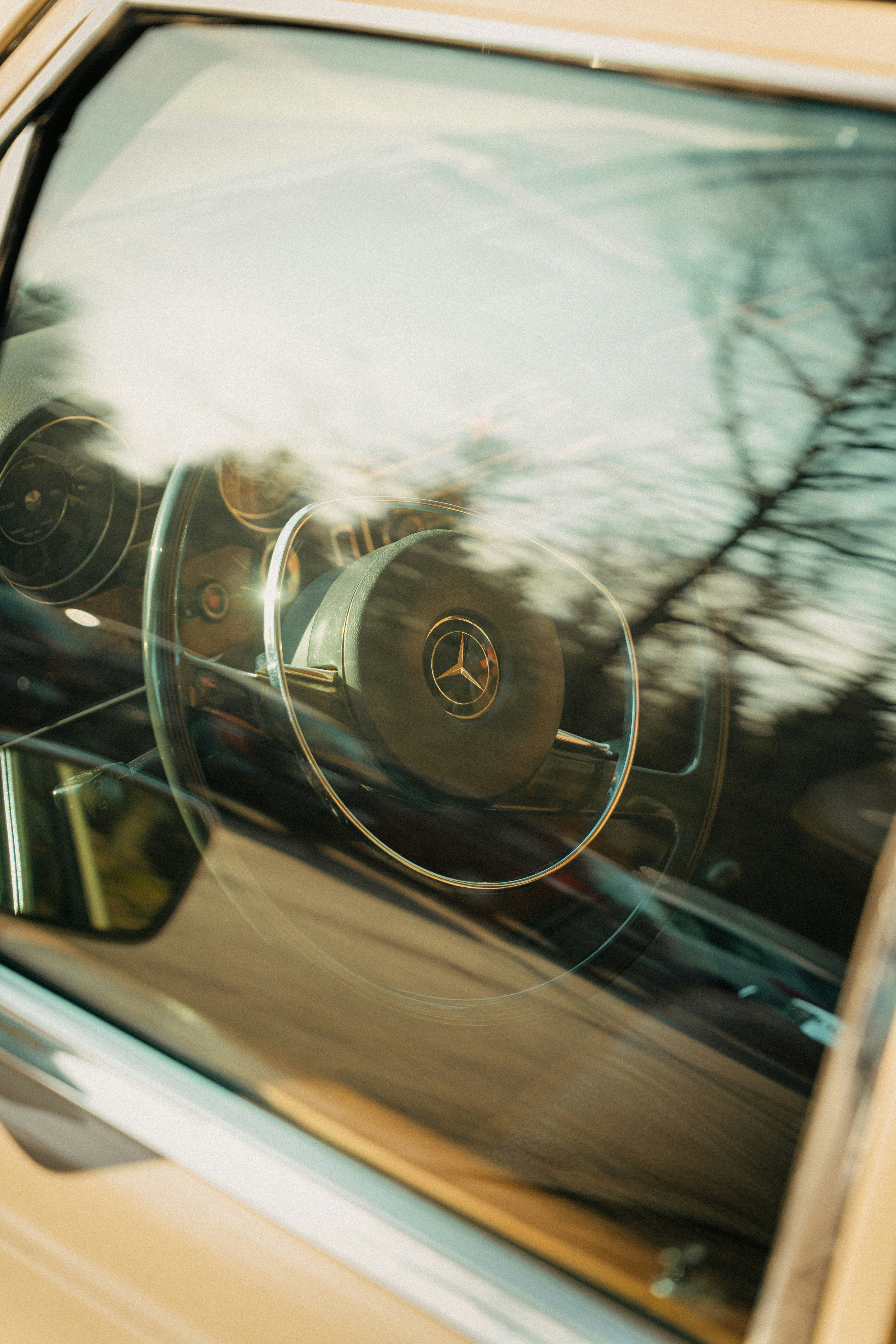Circular Echoes: Mercedes Emblem Framed by Glass and Reflections