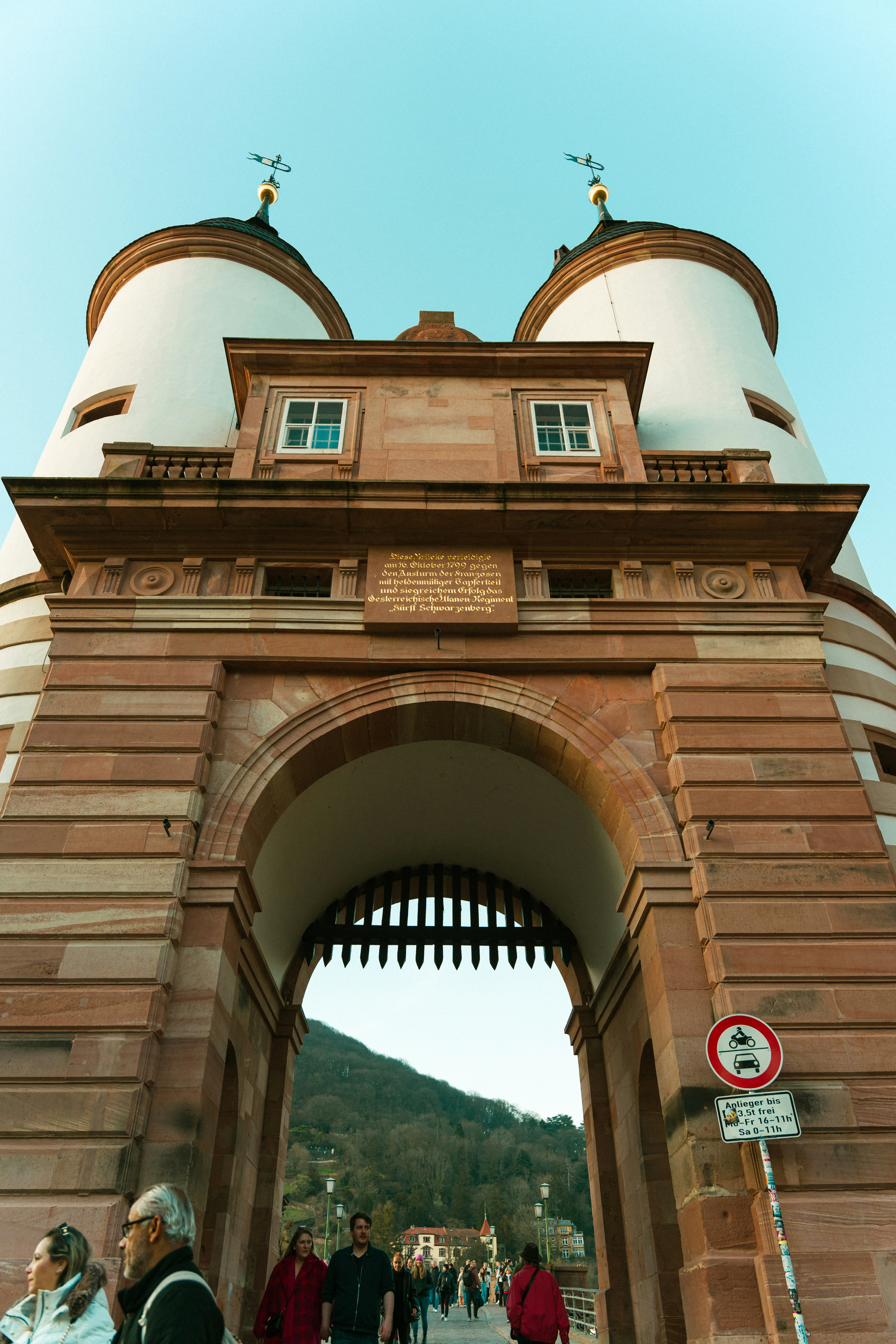 Twin-Tower Archway Framed by a Mountain Village Under a Sky of Blue