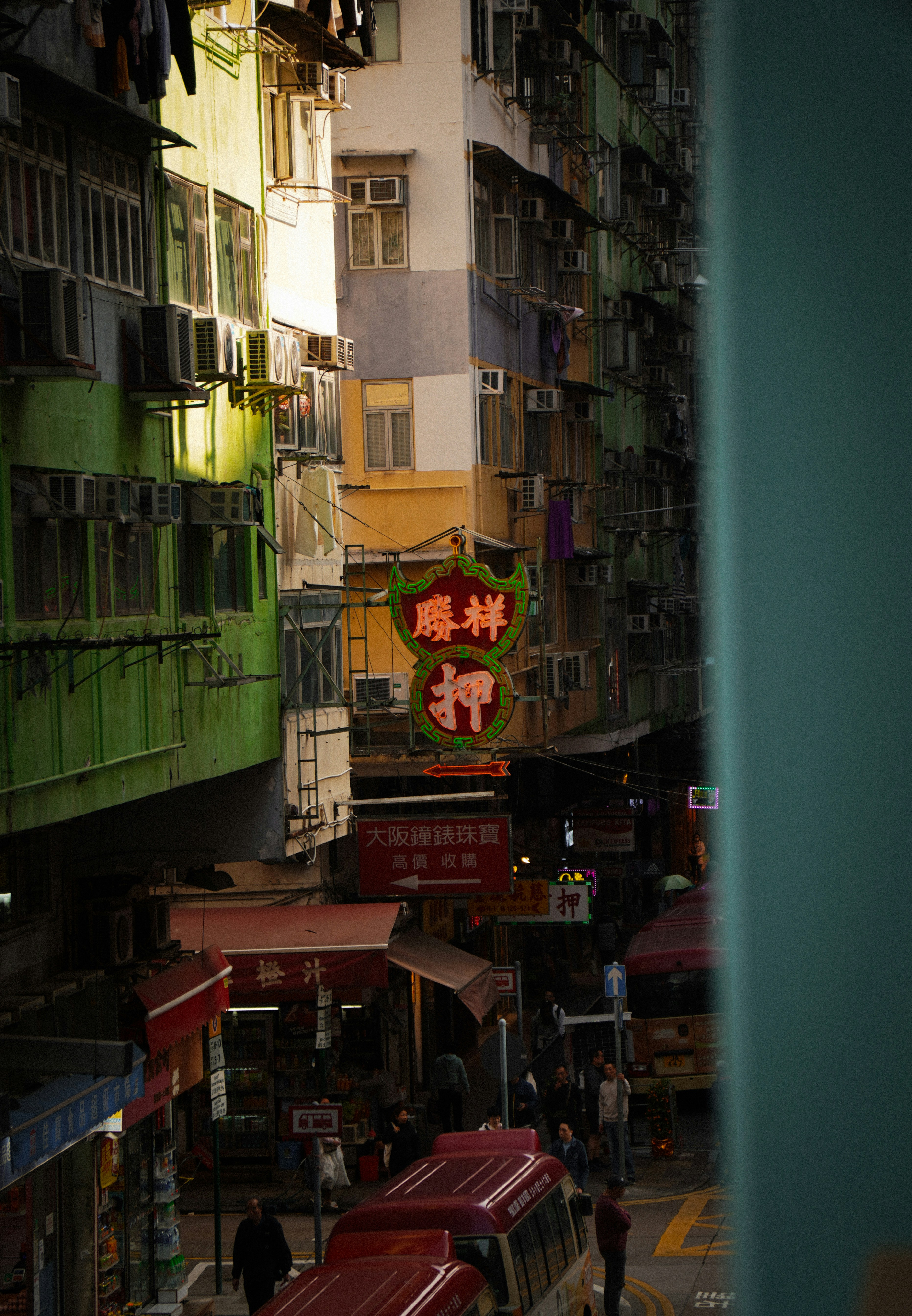 Neon Emblem Over a Colorful Market Alley Between Green Facades