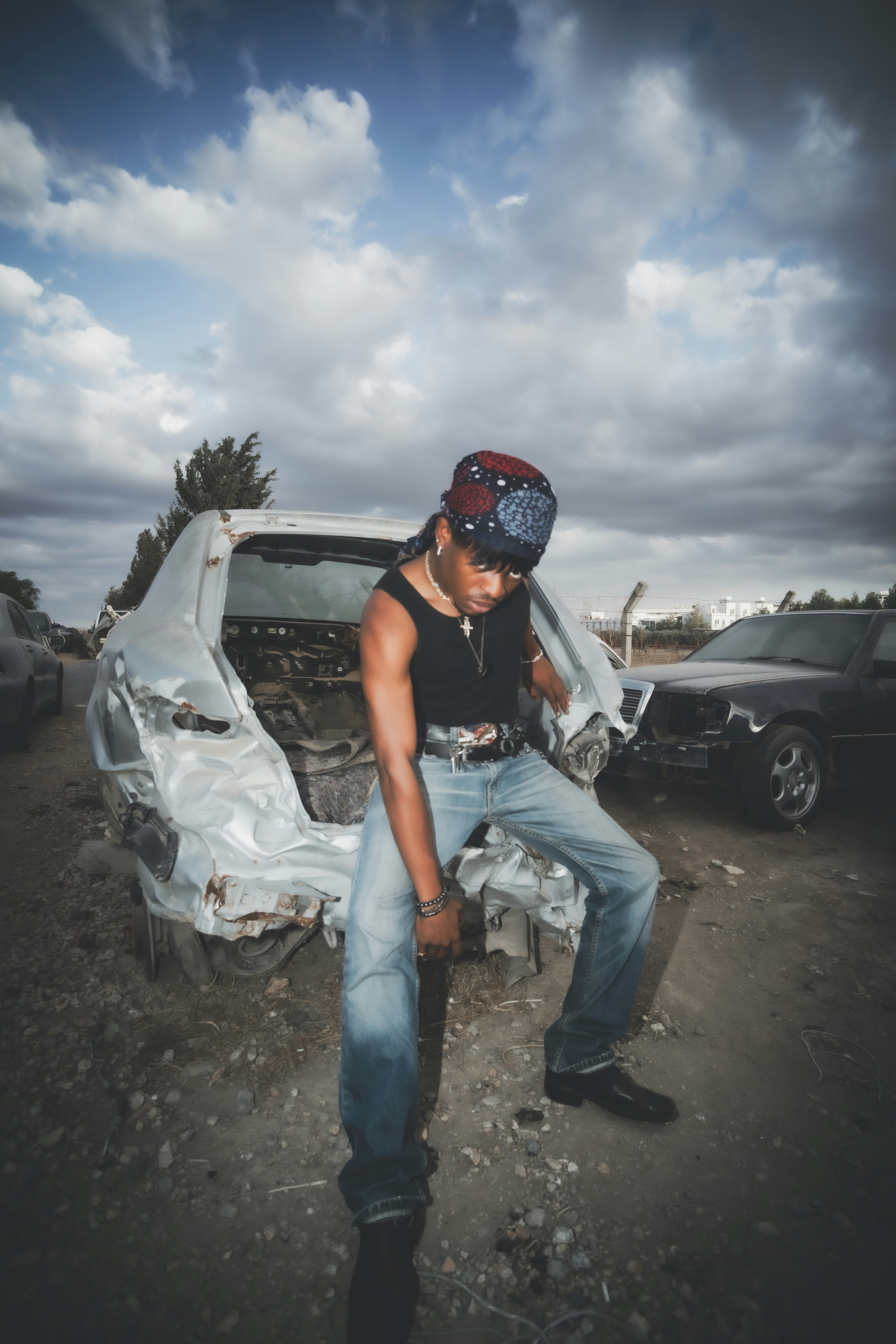 Resilience Amid Rust: Portrait of a Street-Ready Figure in a Junkyard
