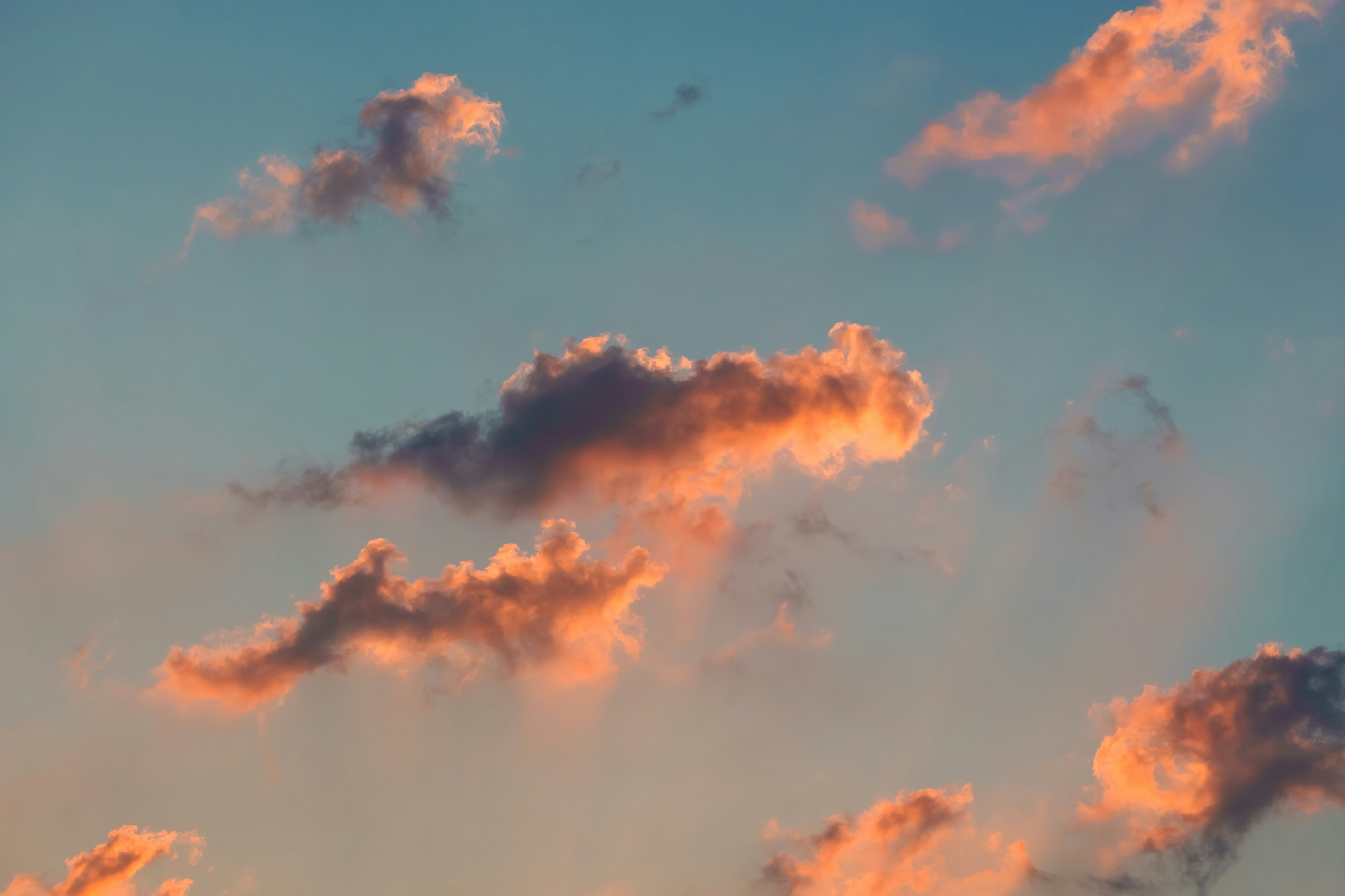 Ember-tipped Clouds Drift Across a Quiet Blue Dusk