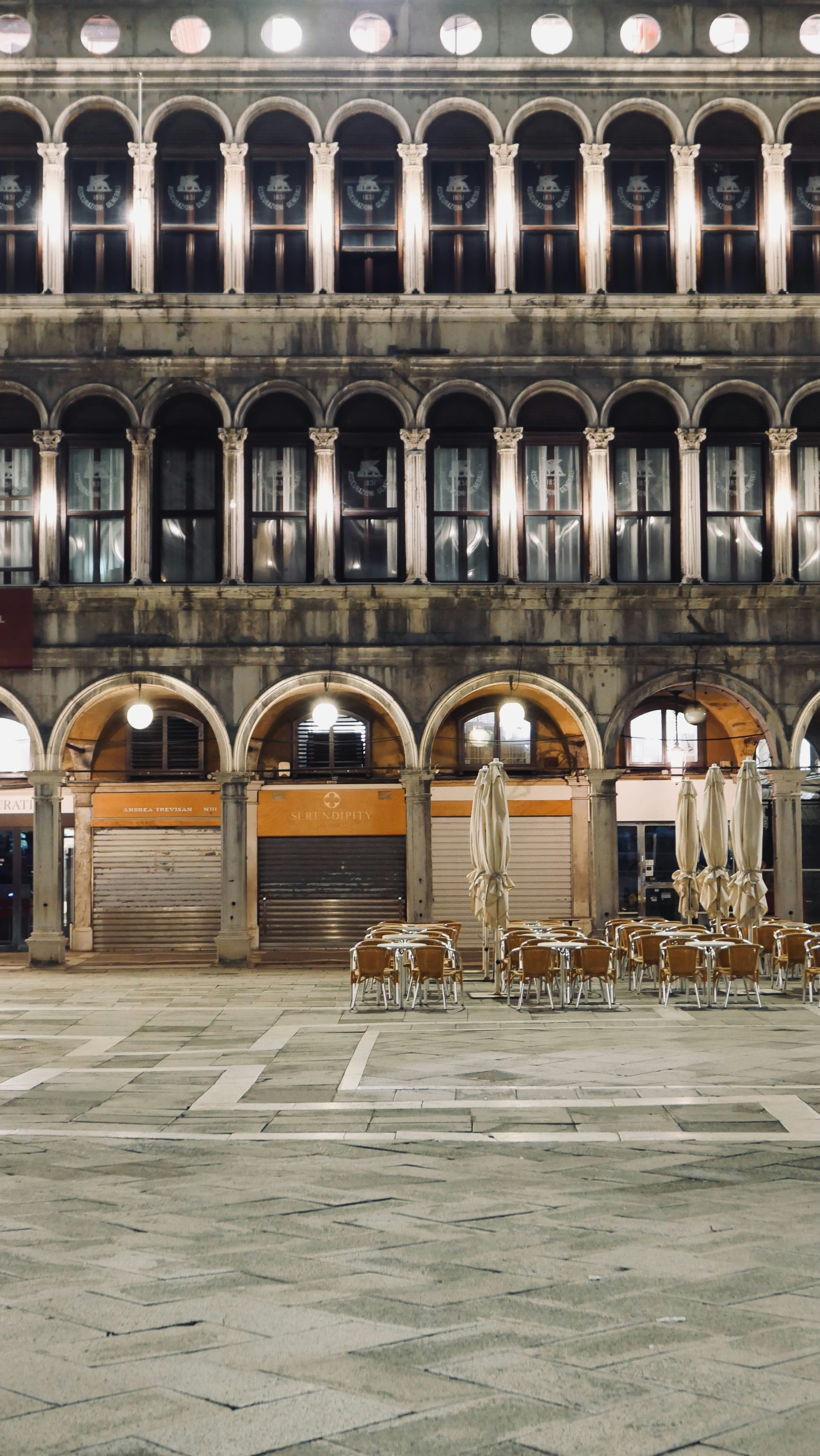 Arcades at Dusk: A Quiet Piazza with Empty Café Tables