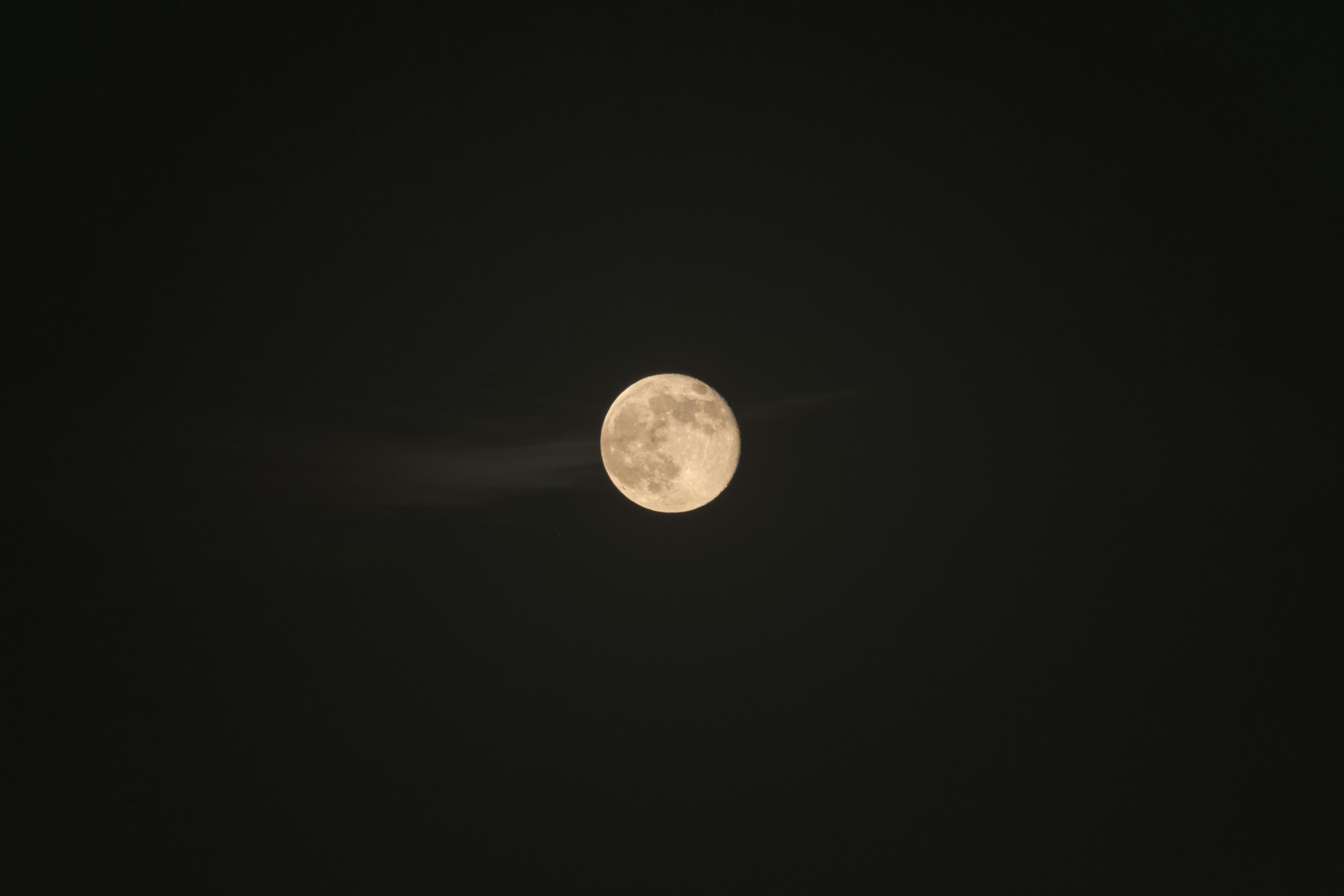 Moonlit Quiet: The Full Moon Emerges Through a Thin Cloud