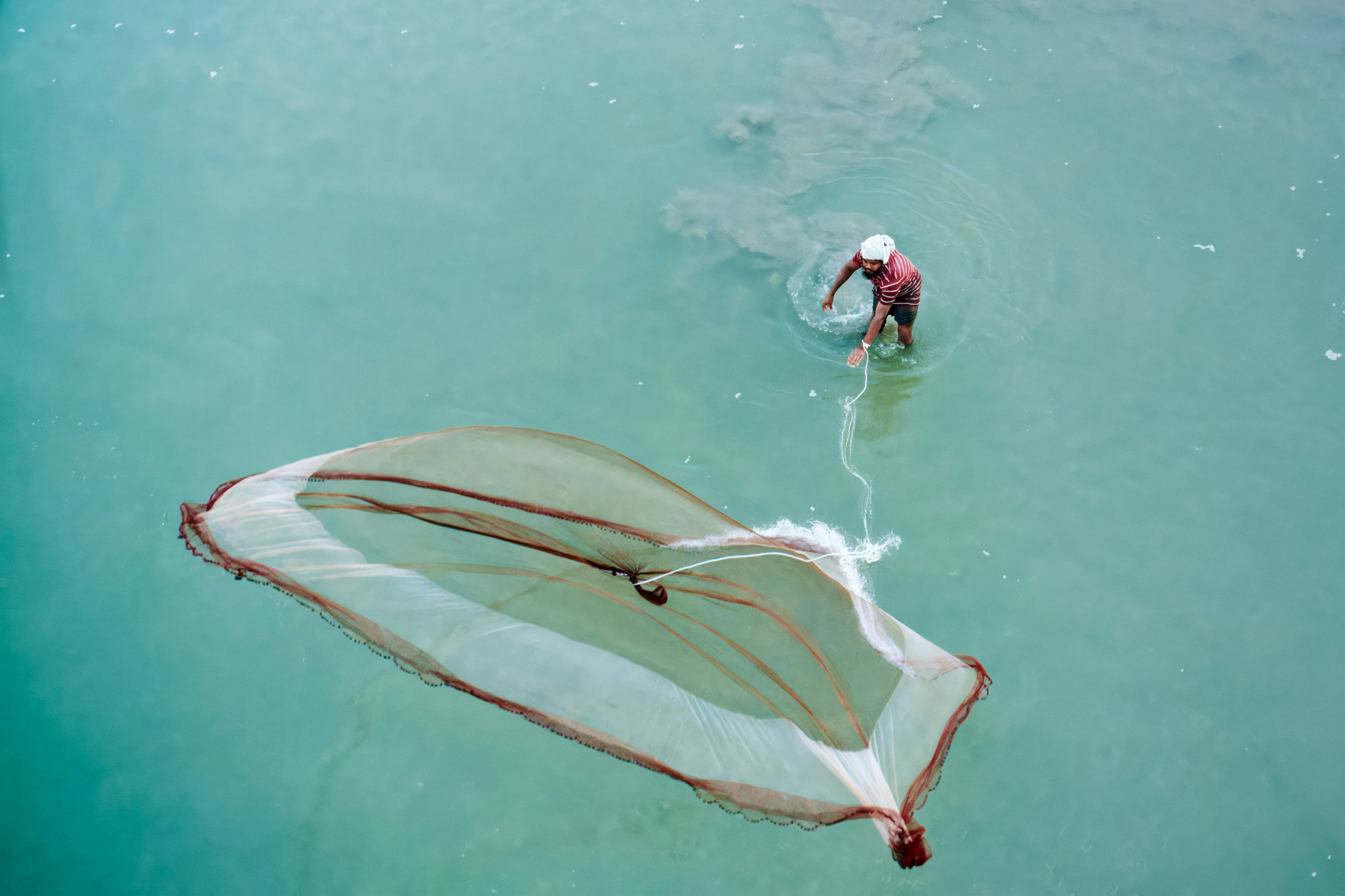 Emerald Seas: An Aerial Portrait of a Fisherman and His Net