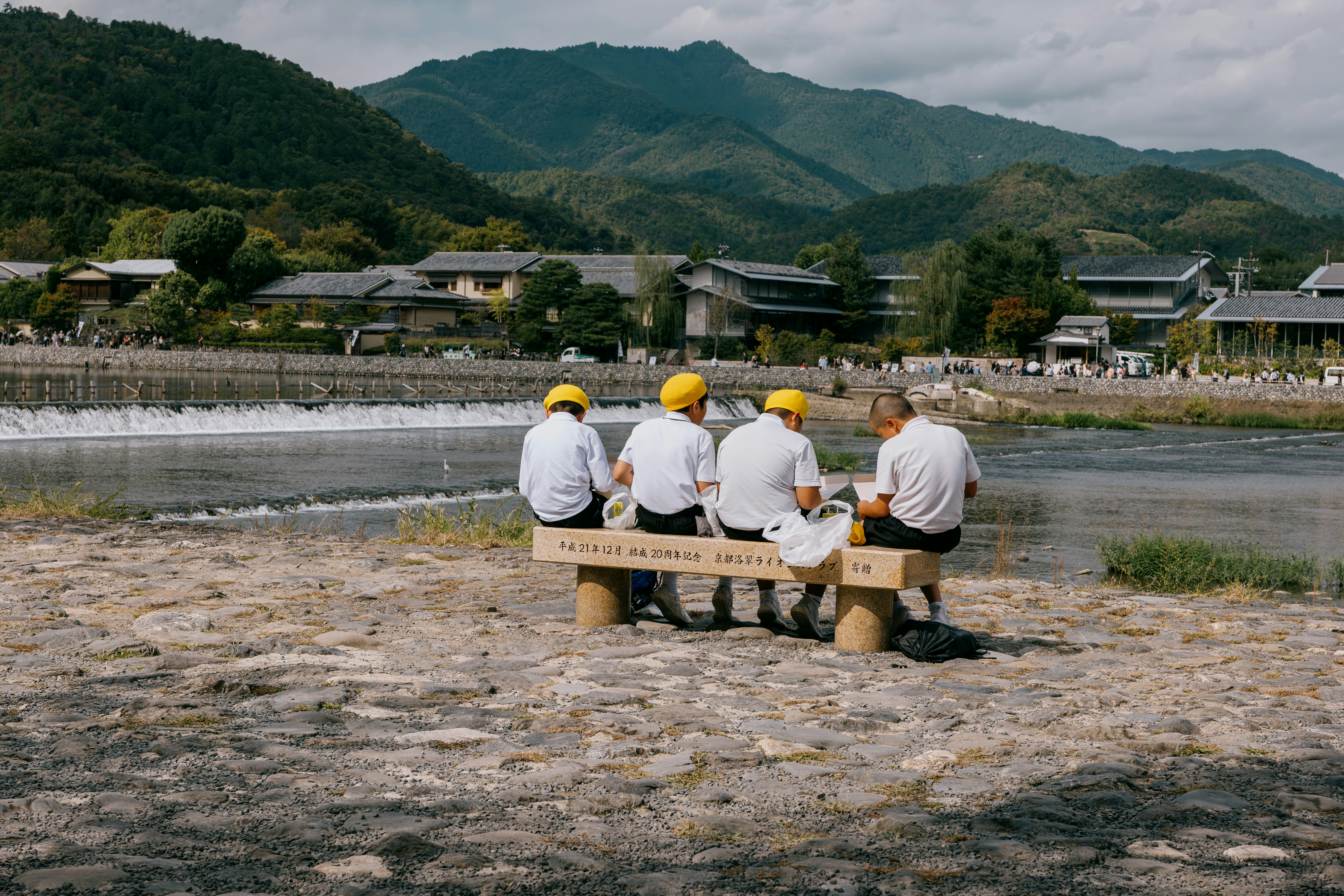 Four people in yellow hats sit on a bench photo – Free Japan Image on ...