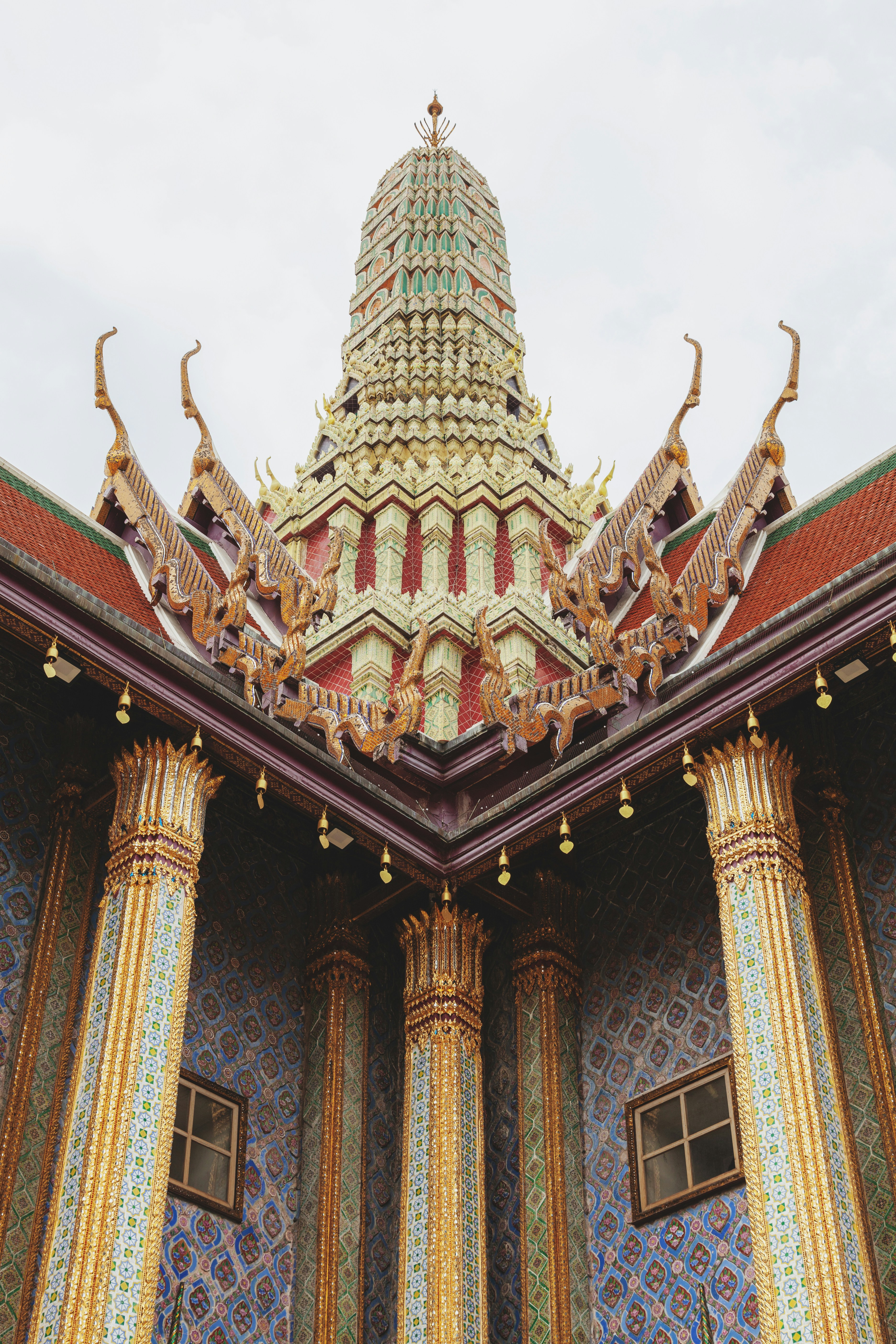 Emerald-Tiled Prang Ascends Over Ornate Thai Colonnades